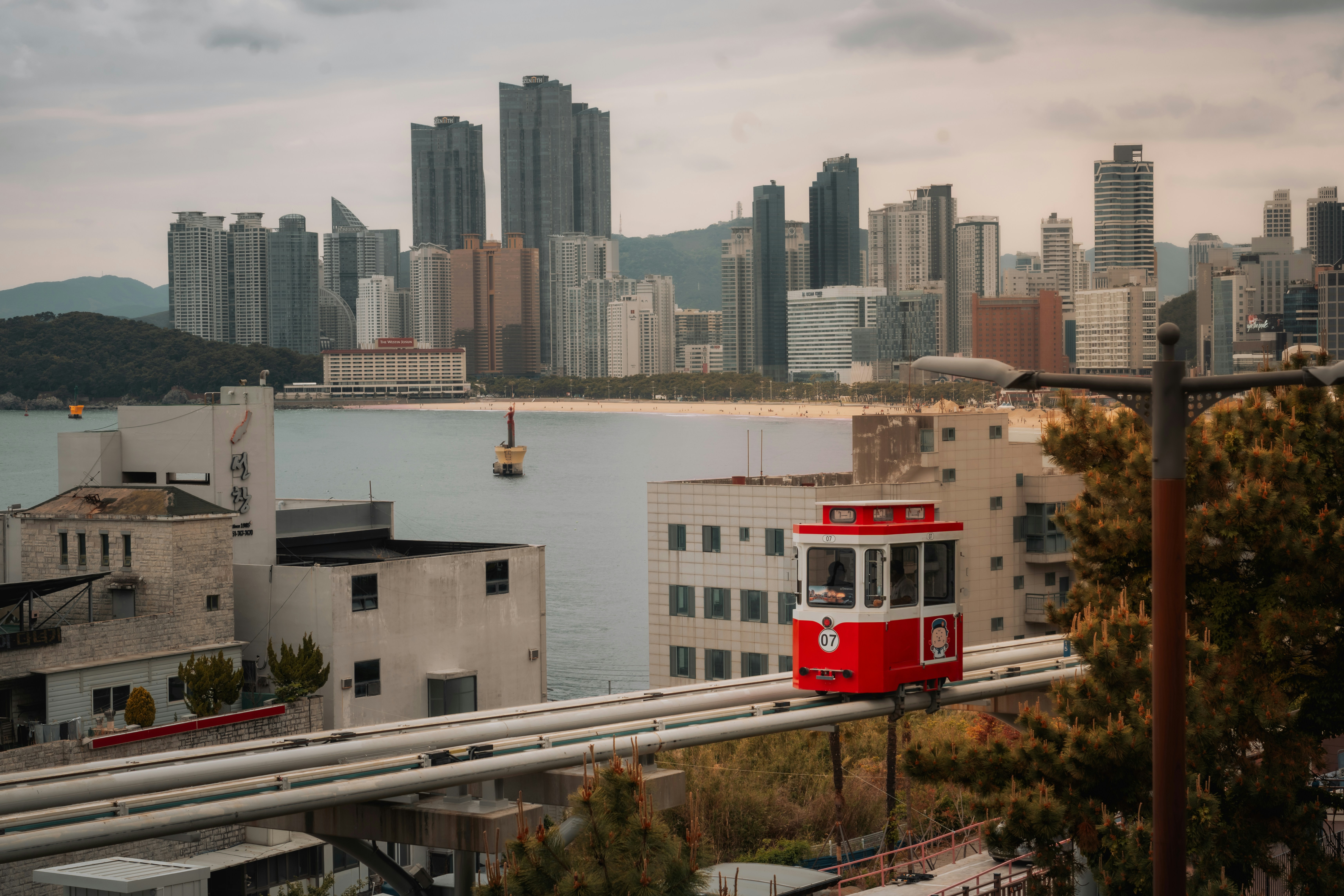 Red Cable Car Prowling Across an Urban Waterfront