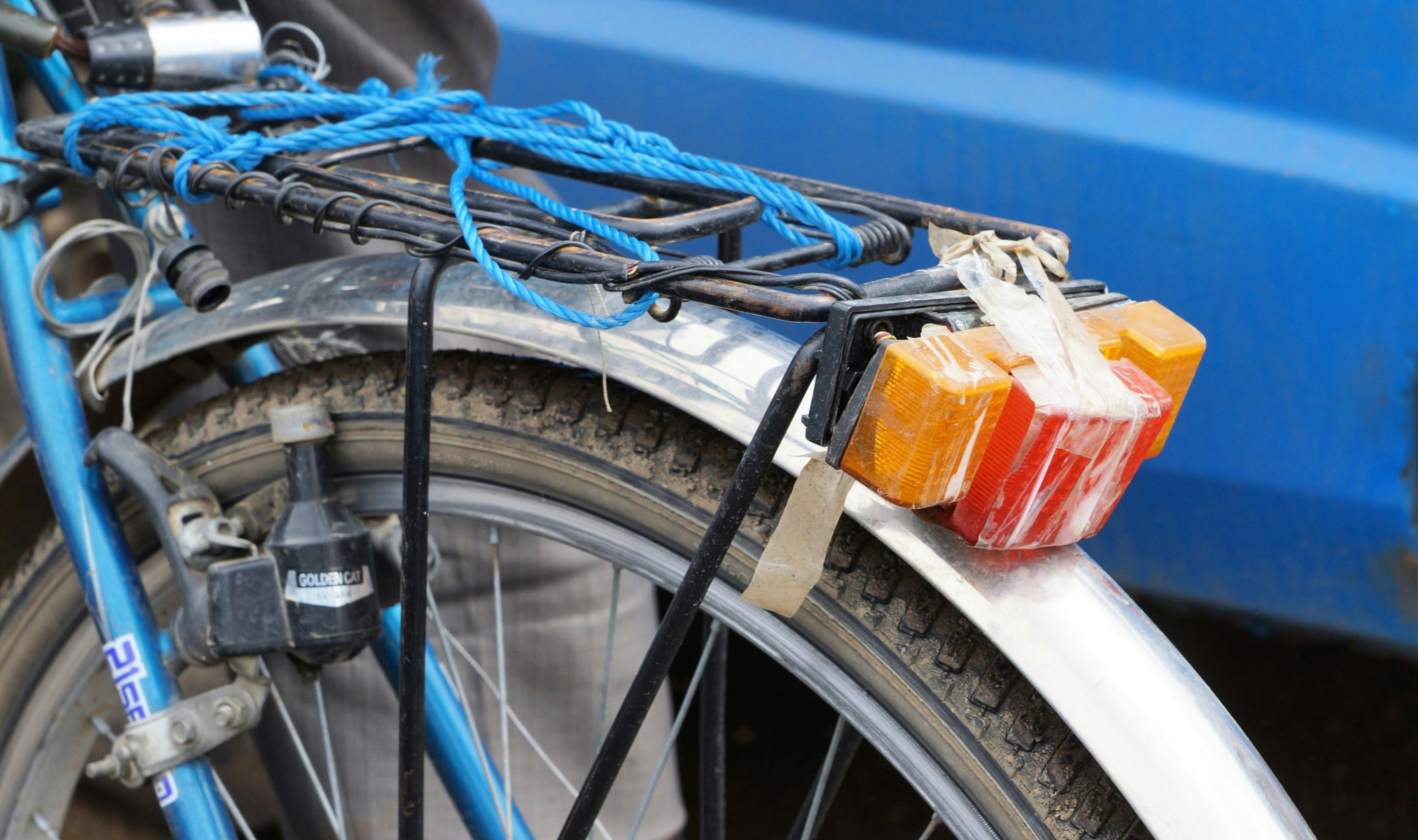 Rear Cargo of a Delivery Bicycle: Axle, Tire, and Tail Light in Focus