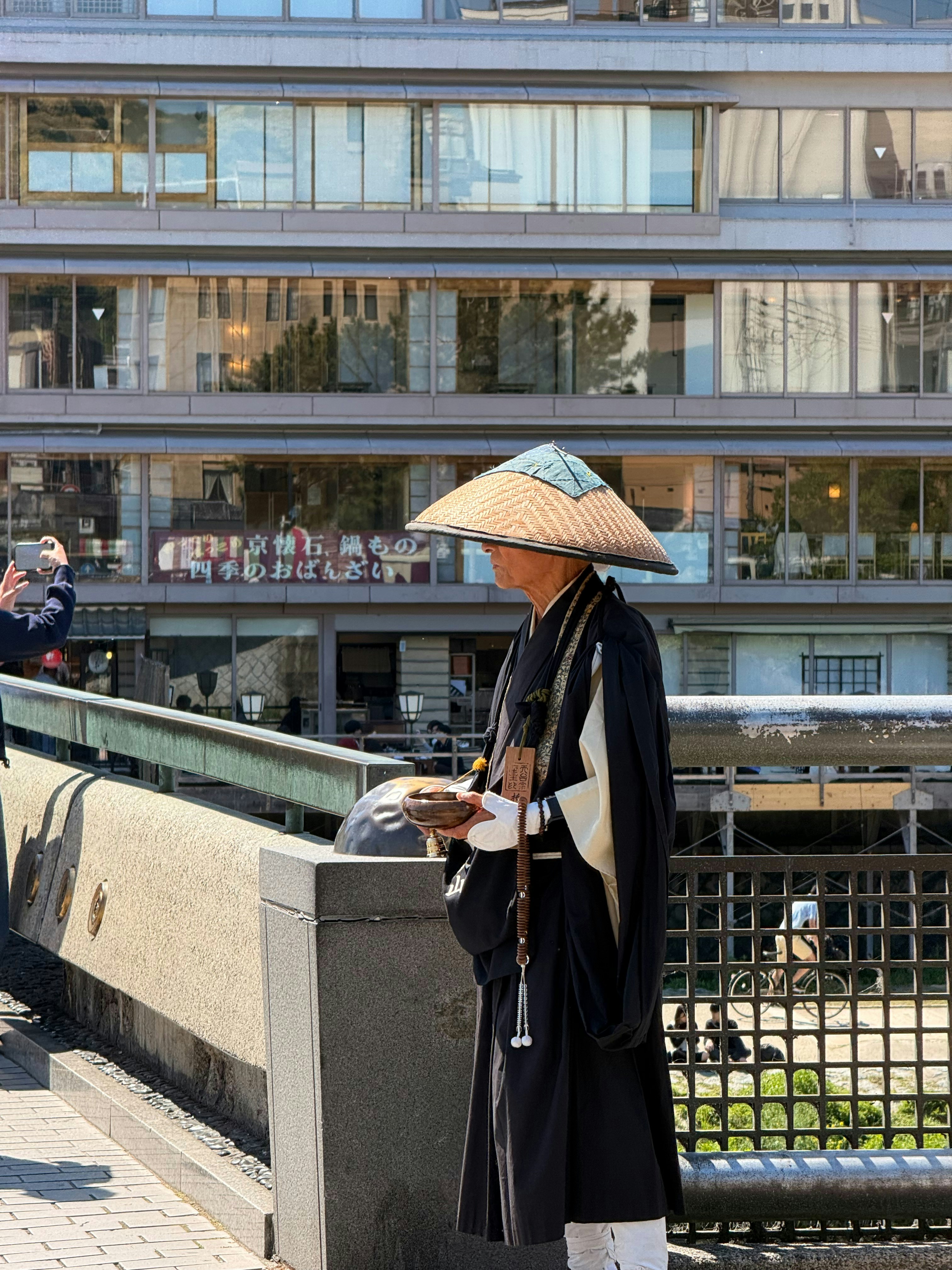 Monk in a Cityscape: Silent Steps with a Paper Cone Hat