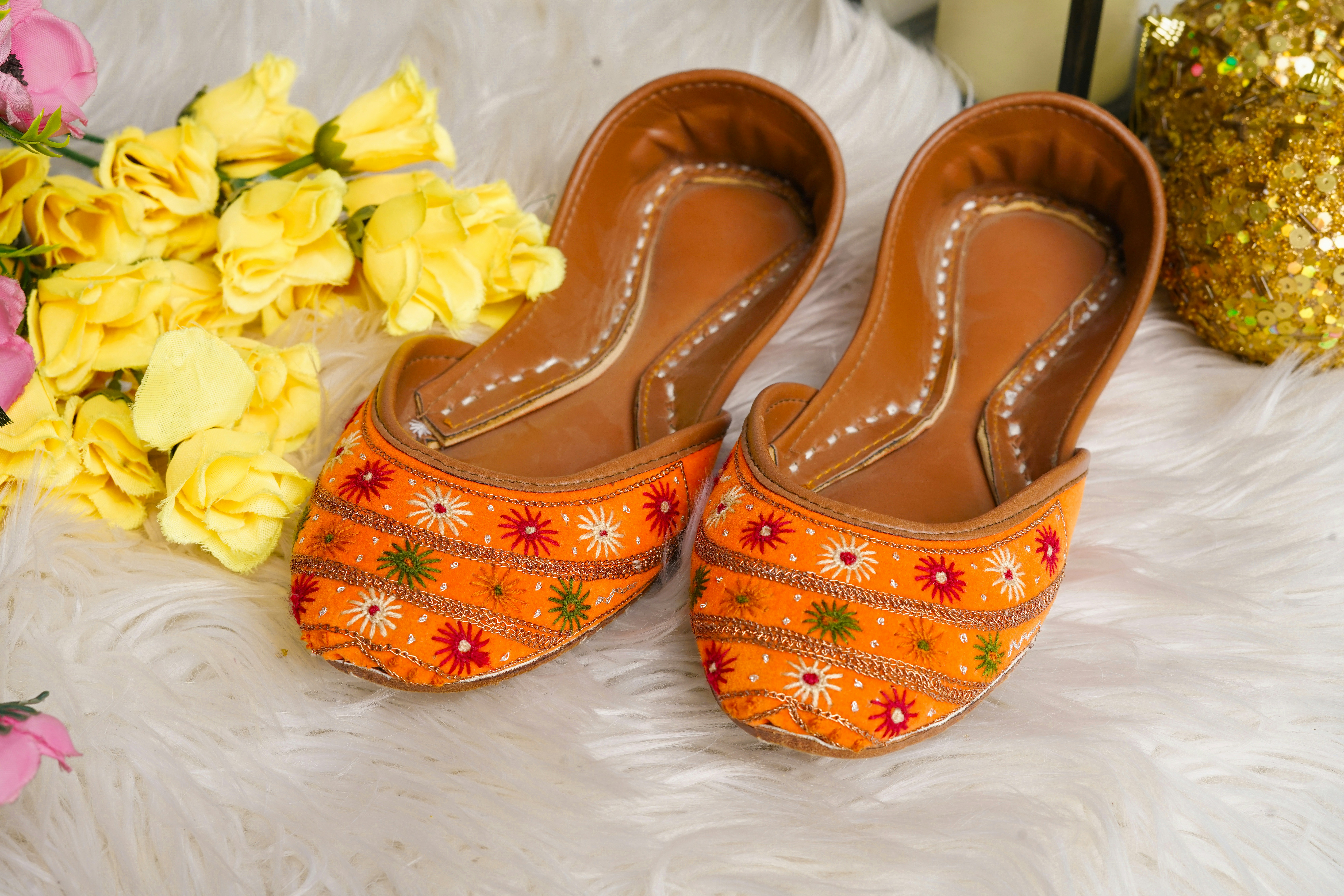 Embellished Orange Slip-Ons Rest on a Plush White Rug