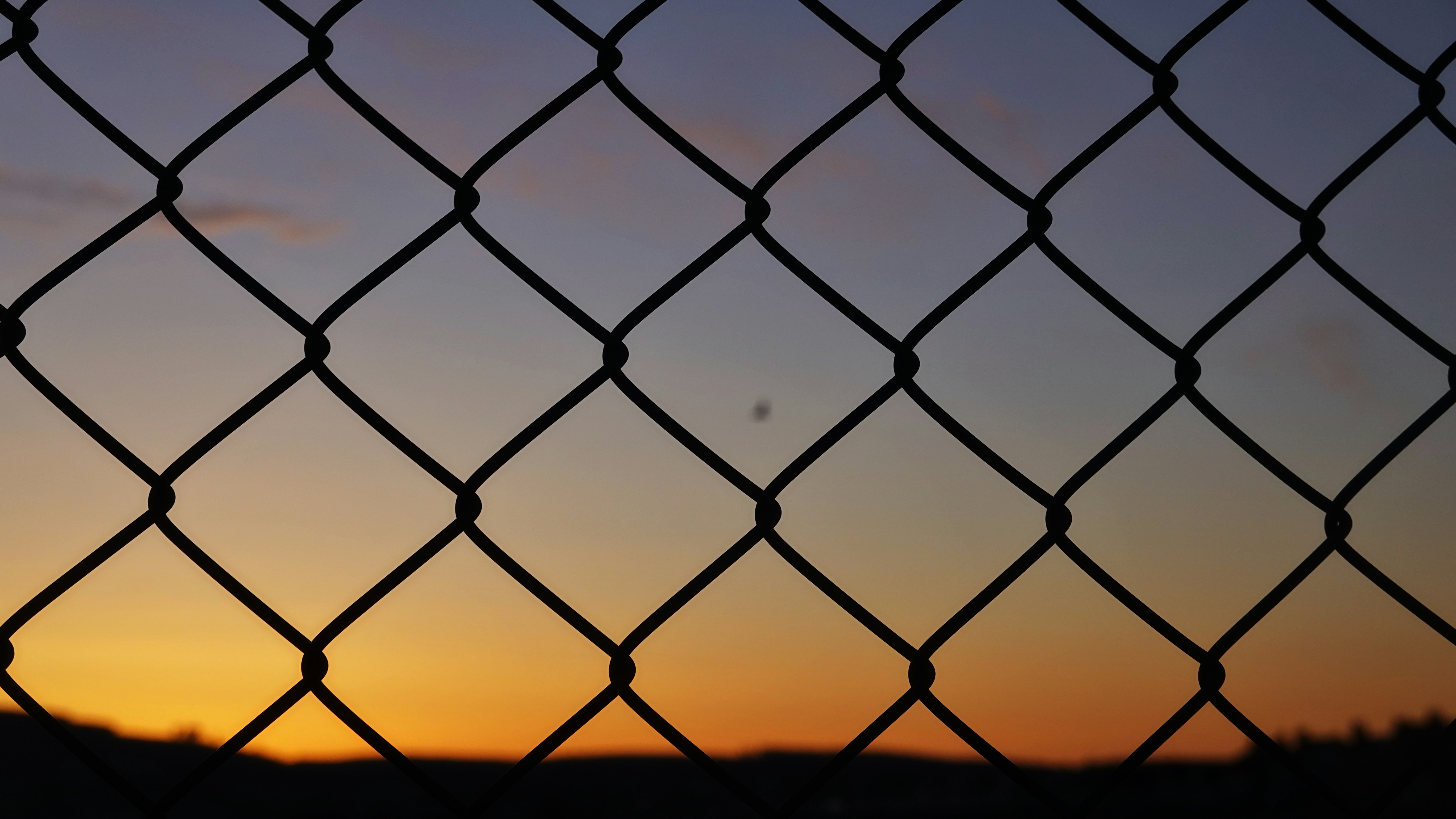 Sunset Beyond the Fence: A Quiet Boundary Between Sky and Ground