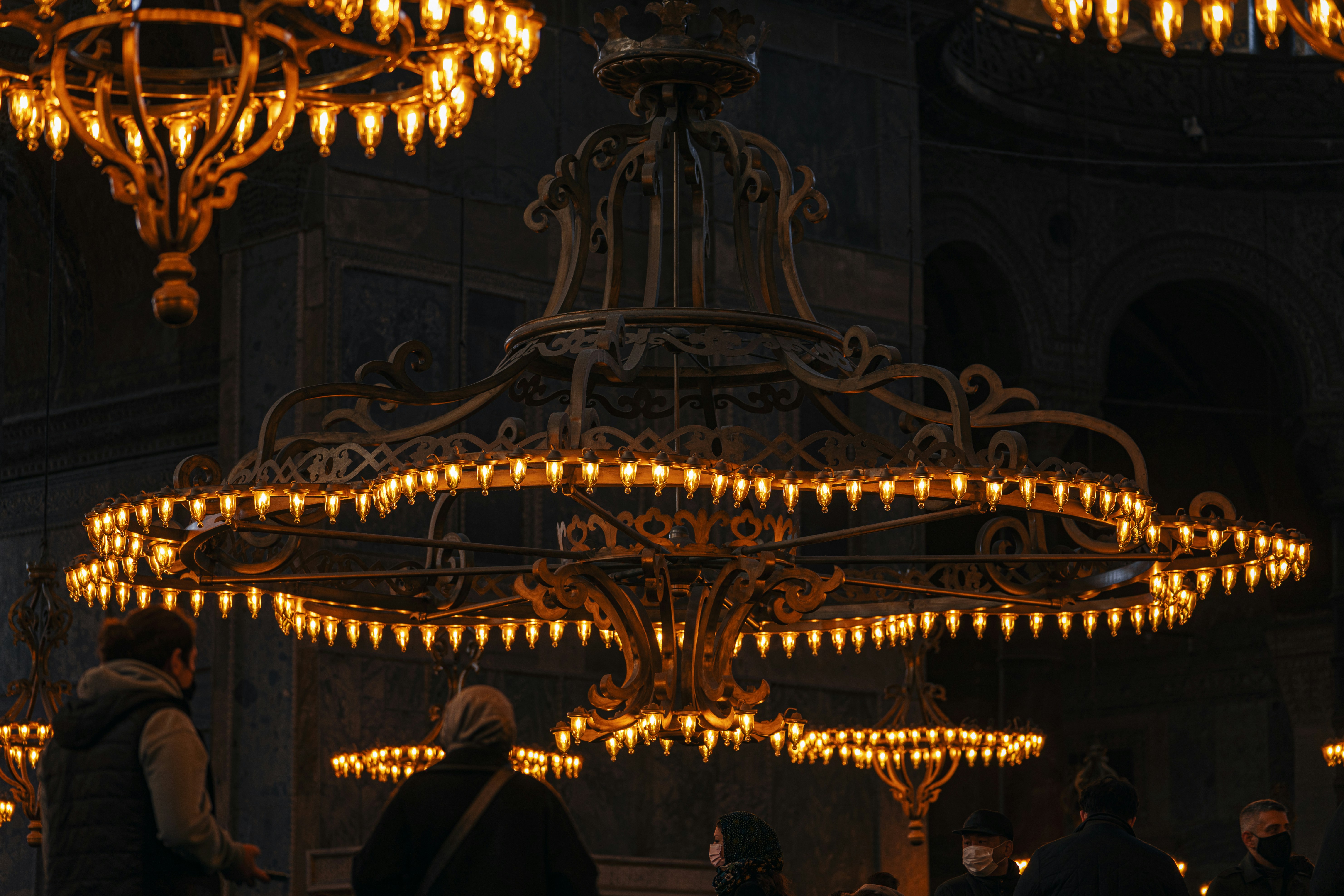 Ornate Chandeliers in a Dim Hall Cast in Warm Glo