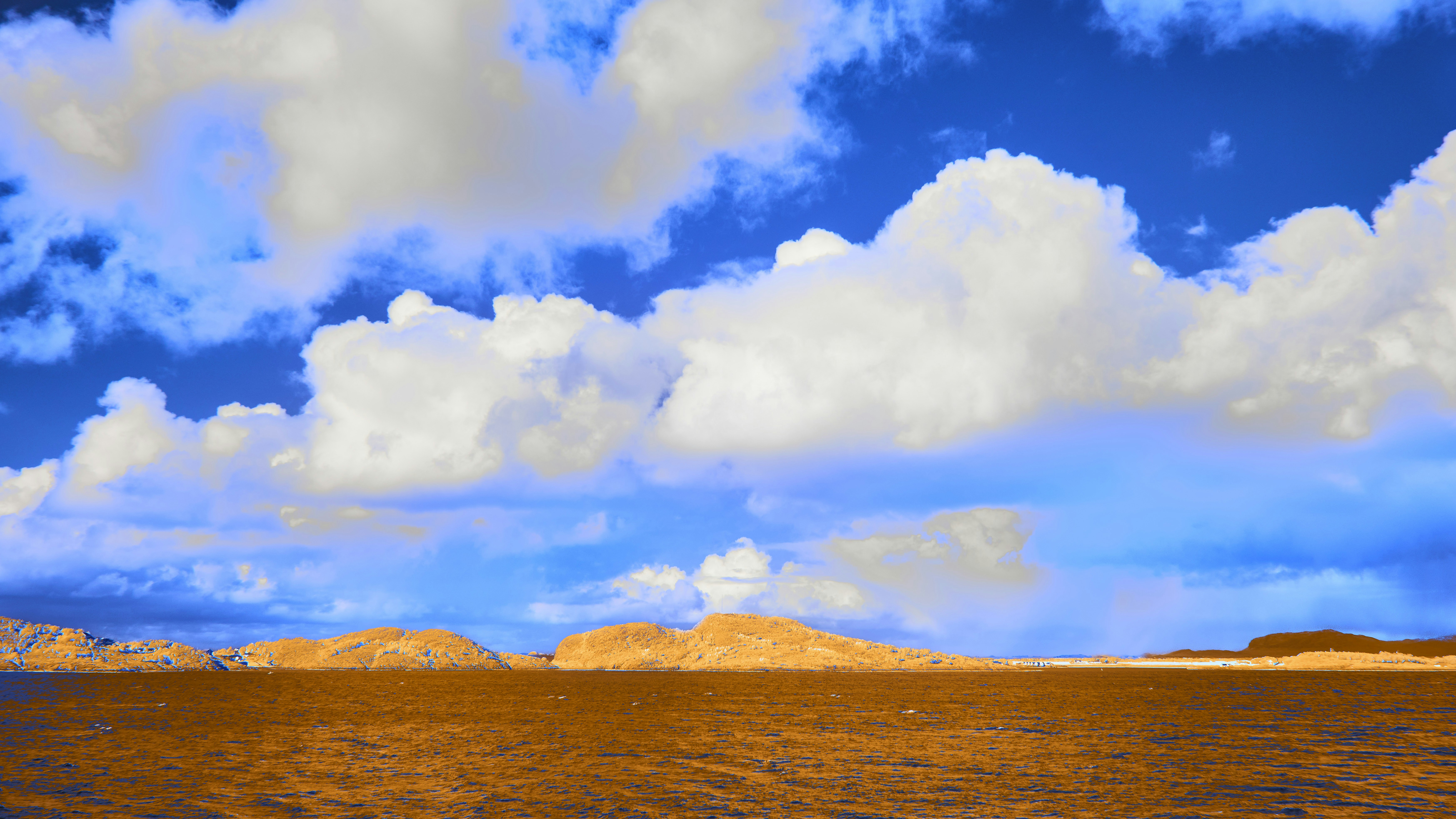 Desert Skyline: A Tranquil Horizon Beneath Wide Blue Clouds