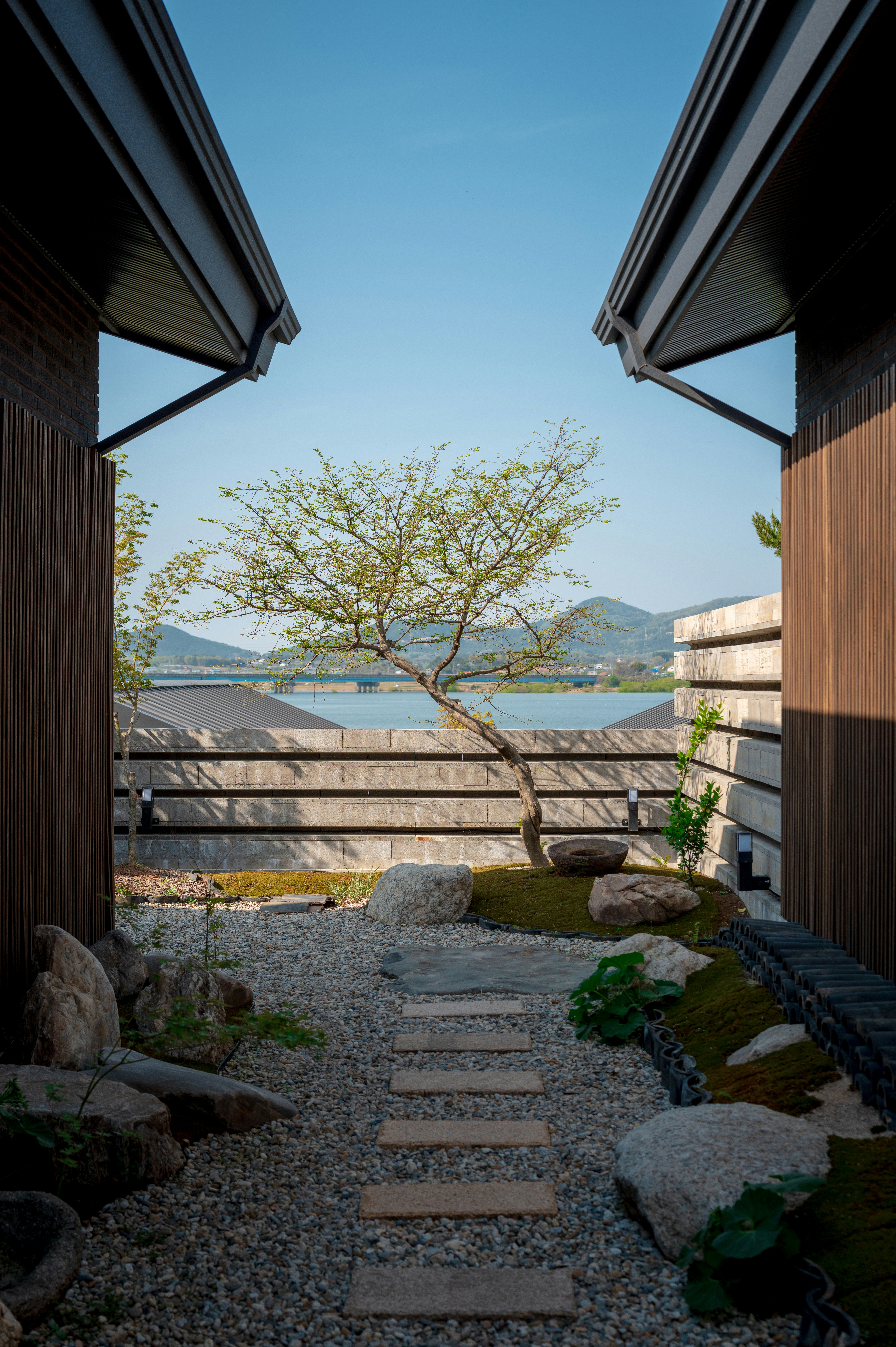 Midday Path to Serenity: An Upper Courtyard Framed by Sails and Sea