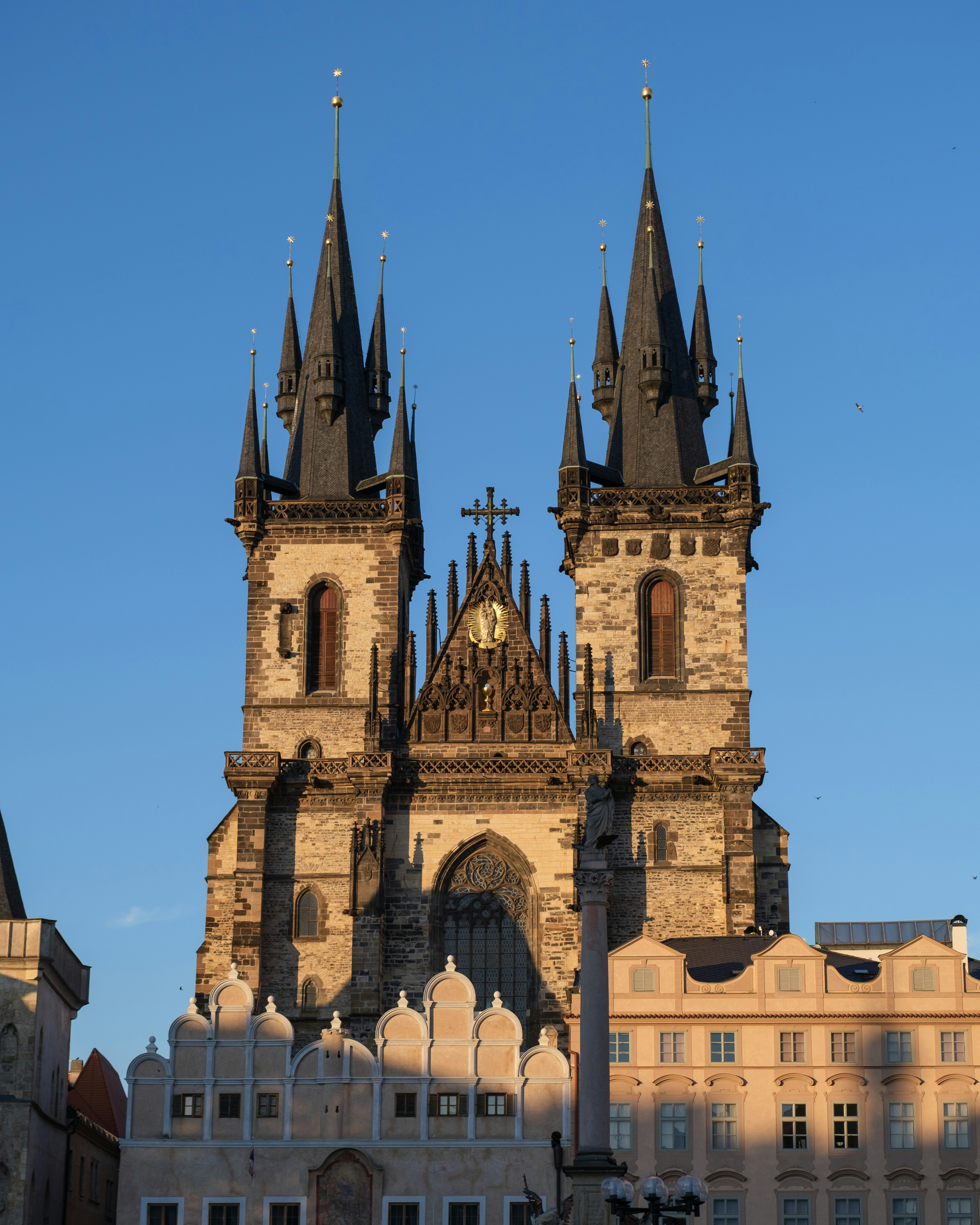 Twin Spires at Dusk: Gothic Facade Rising Above Prague-Style Row