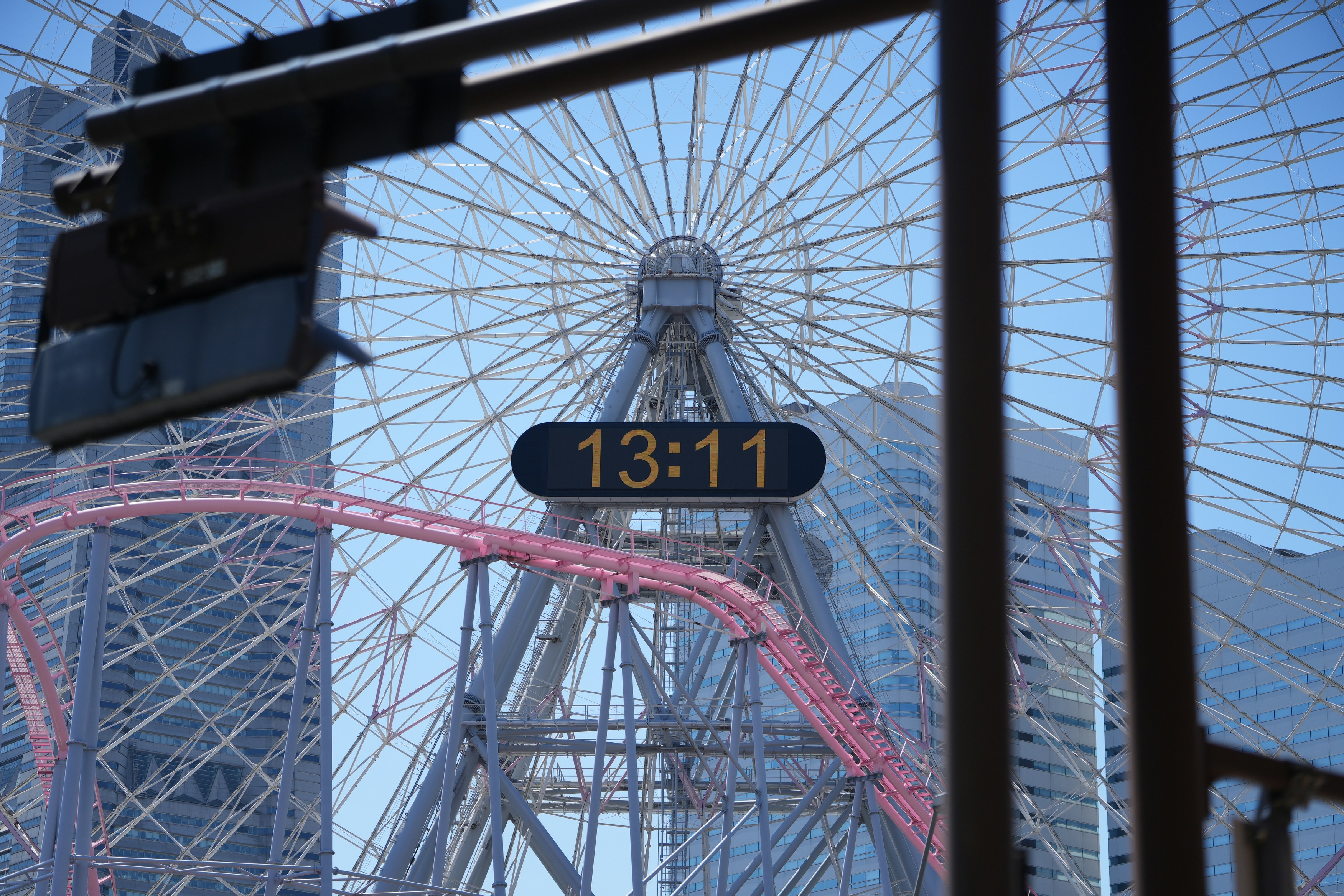 Timekeeper Above the Rails: Ferris Wheel Silhouettes with Neon Sign