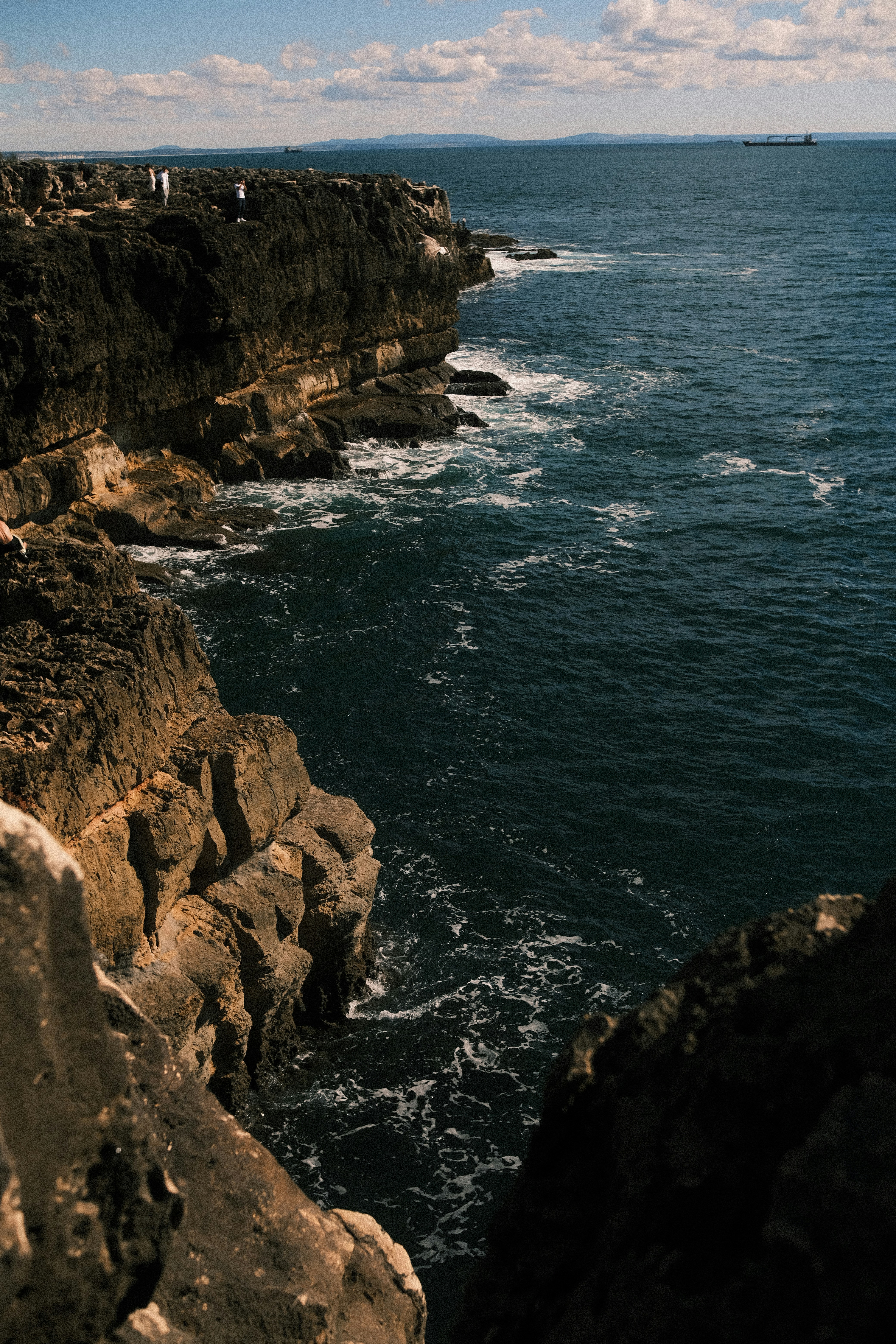 Cliff Edge Vista: Ocean Currents and Distant Hulls