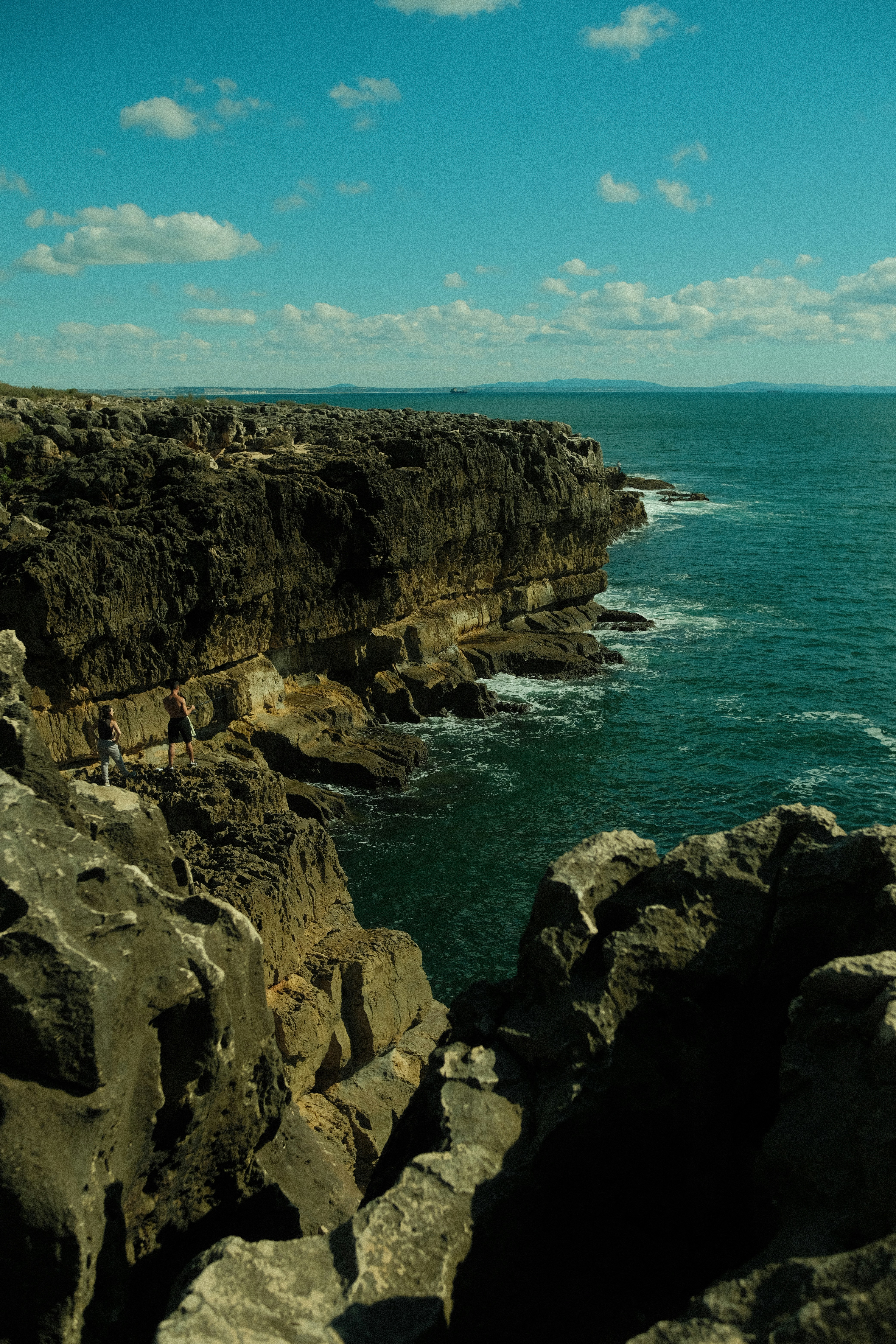 Cliffside Trace: People Exploring Rugged Coastal Formations