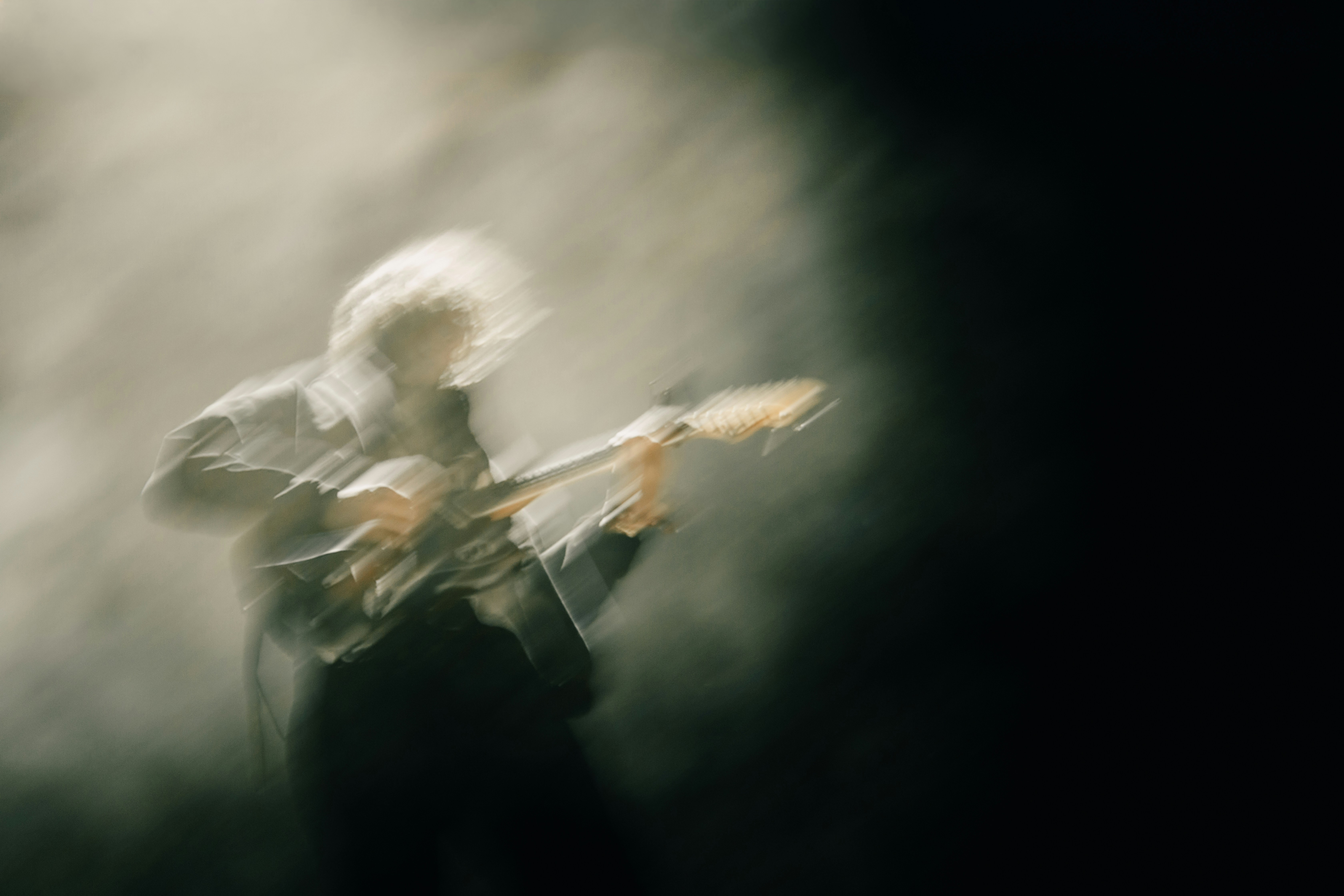 Blurred Guitarist in Mist: A Dreamlike Stage Fade