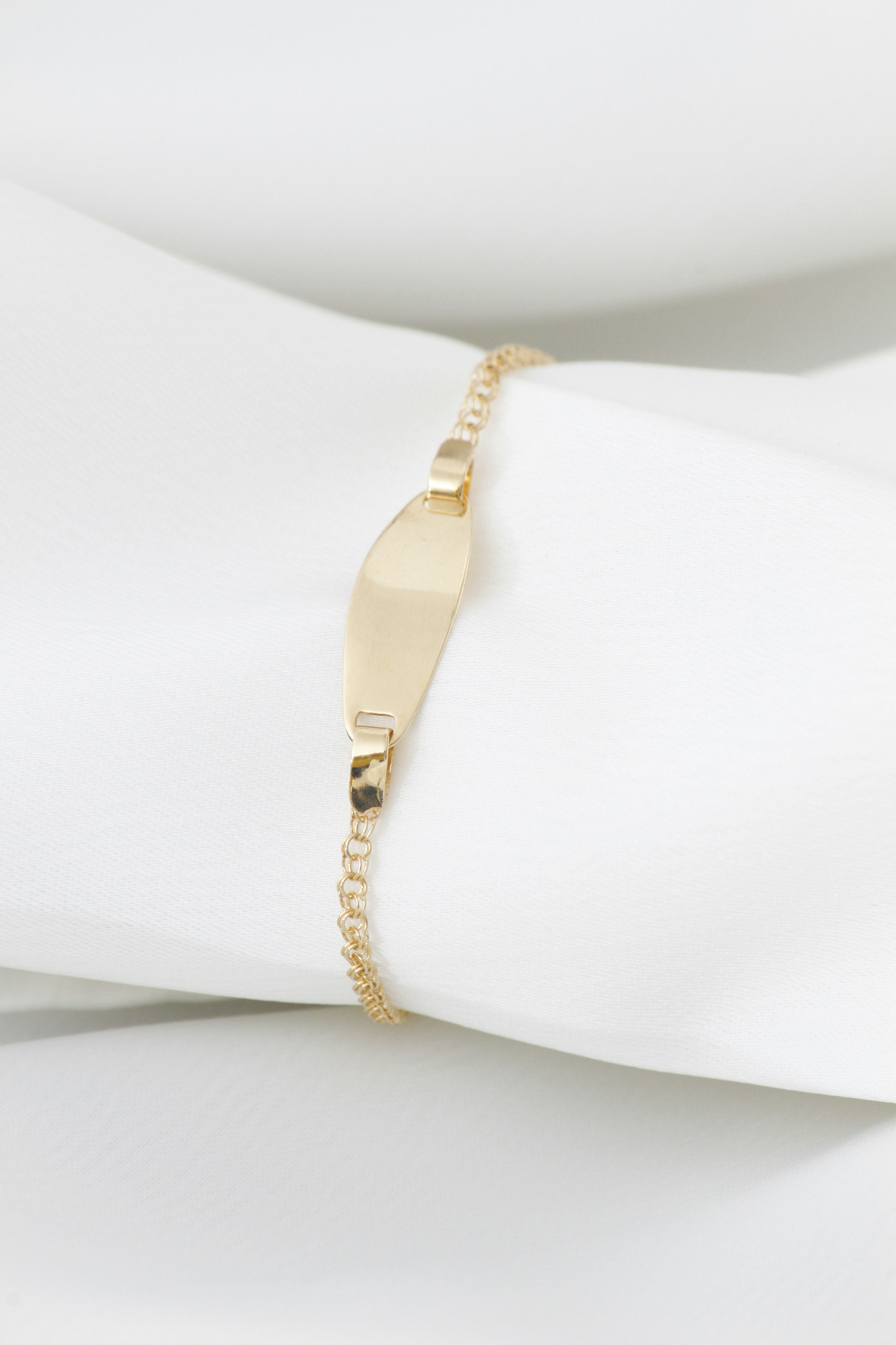 Gold Thread, Hidden Shine: A Minimalist Bracelet on White Silk