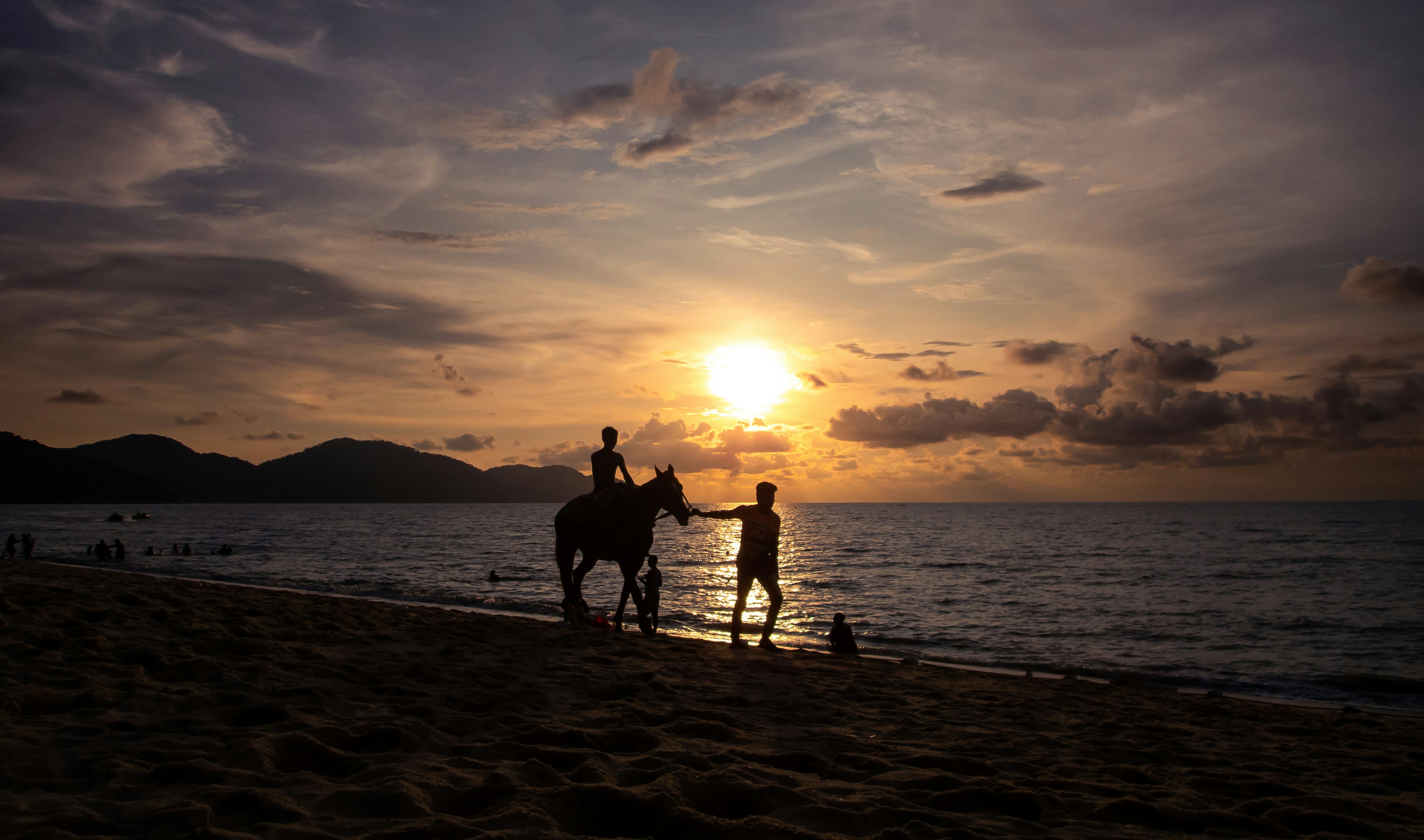 Golden Hour Silhouette: Riders and Beach at Dusk
