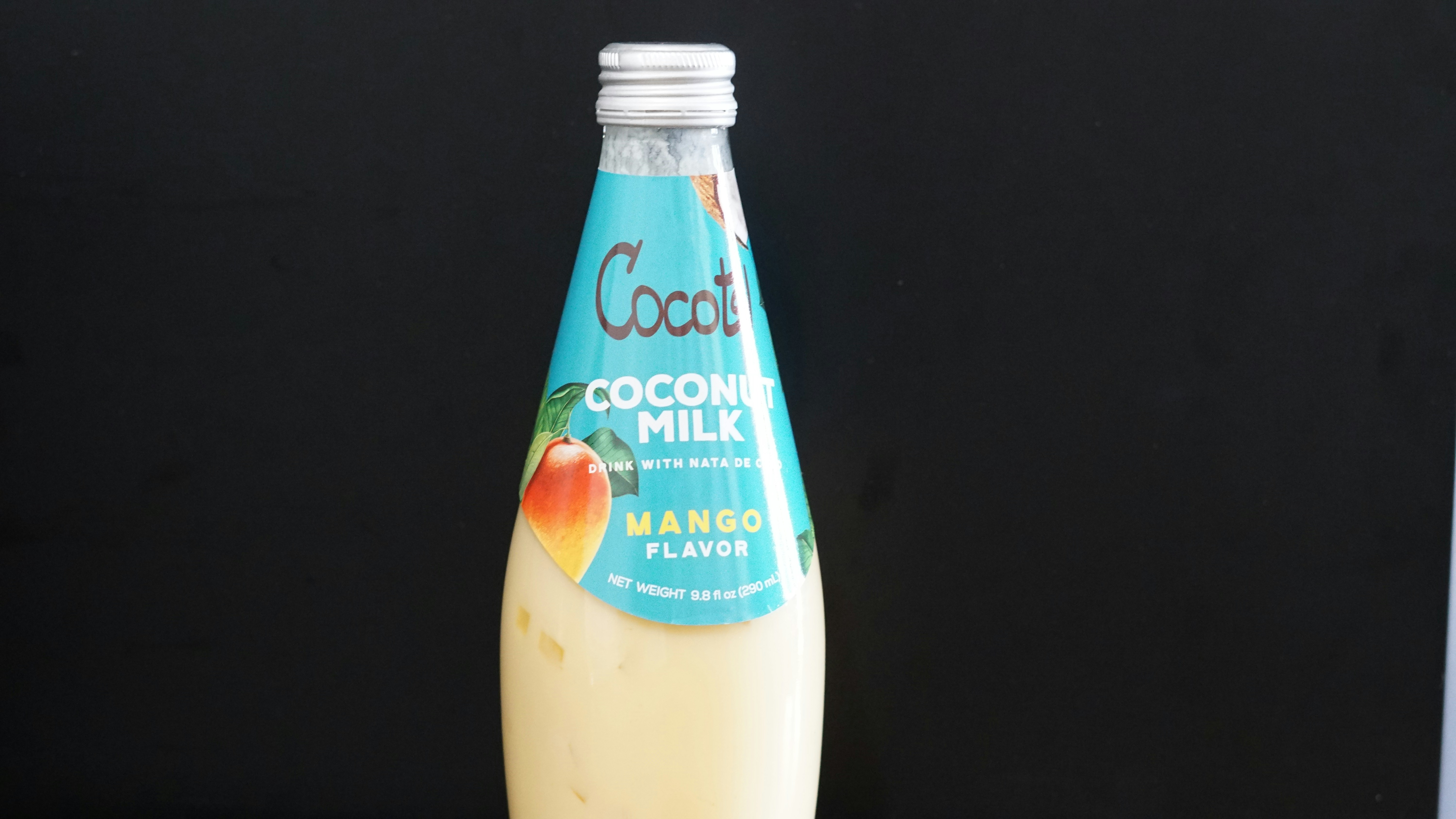  Mango Coconut Milk in a Sleek Matte Bottle Stands Against a Dark Backdrop