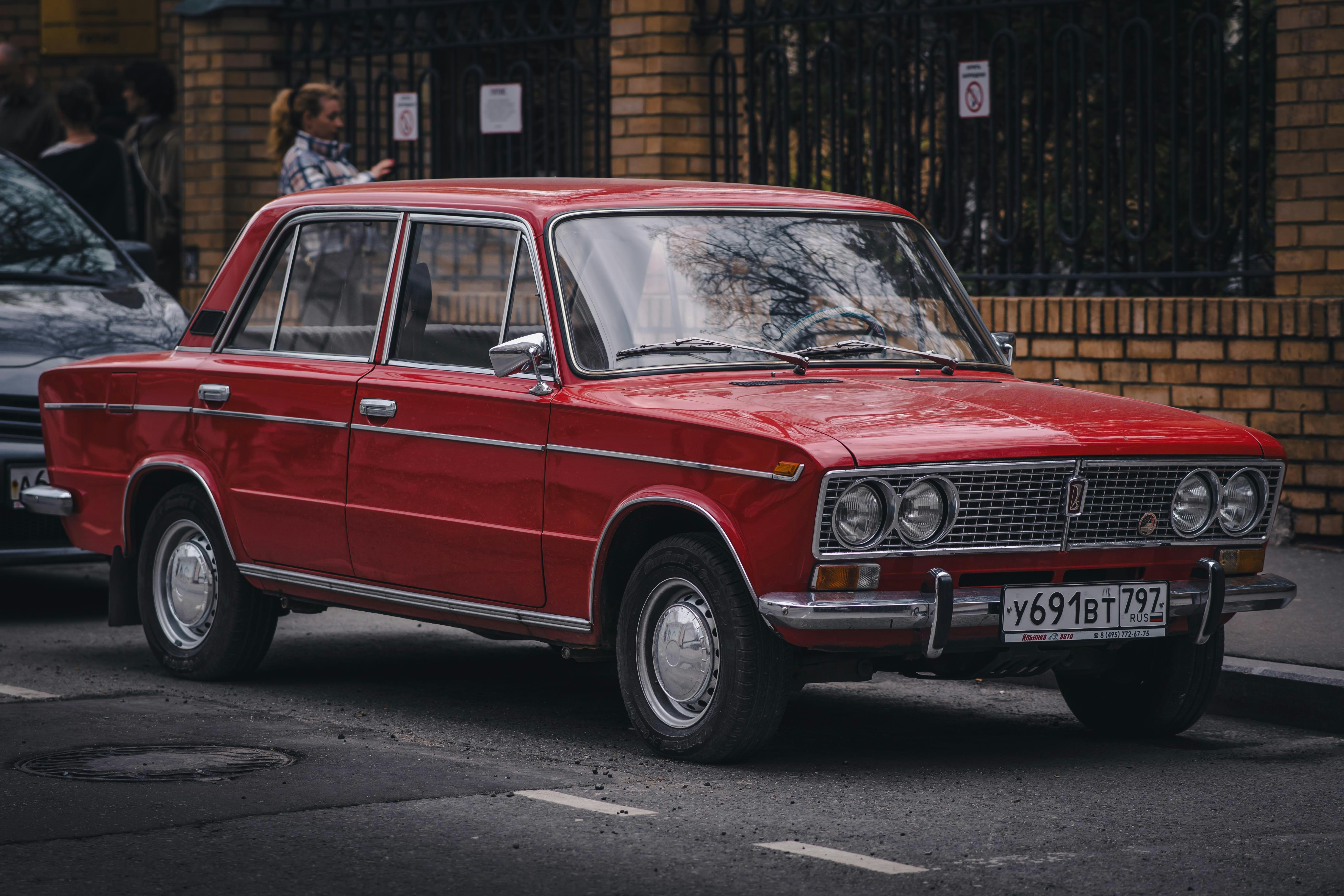 Red Classic: A Timeless Russian-Titled Sedan Resting on a City Street