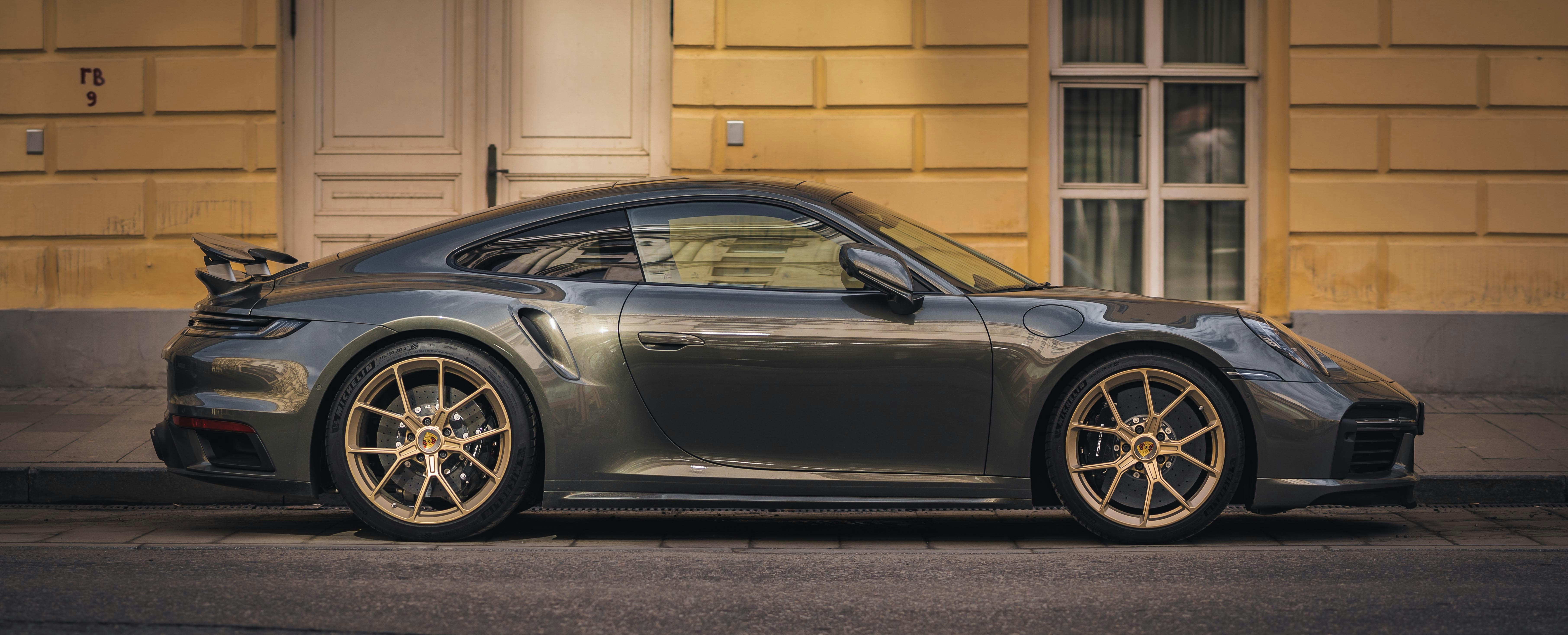Blue-gray Porsche in front of ochre townhouse