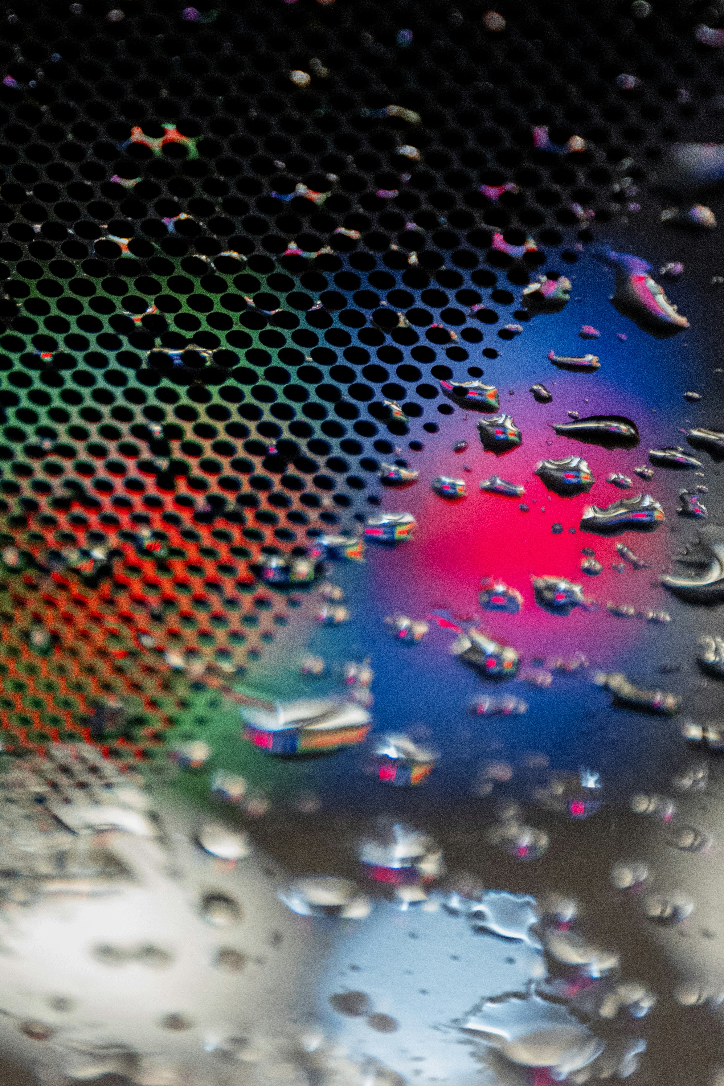 Colorful Rain: Abstract Dots with Rainbow Reflections on Wet Glass