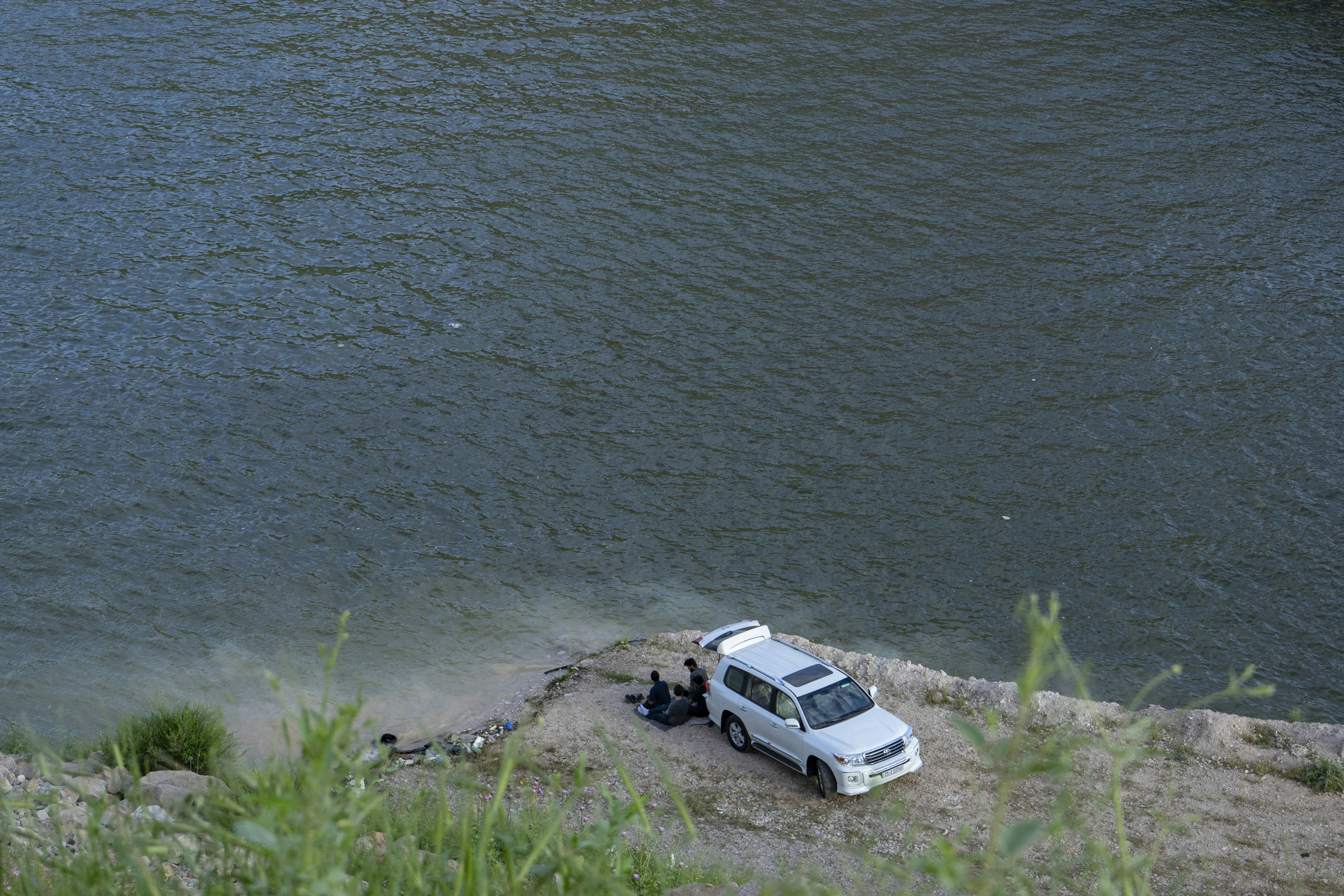 Clifftop Rest: A White SUV Pauses Above the River
