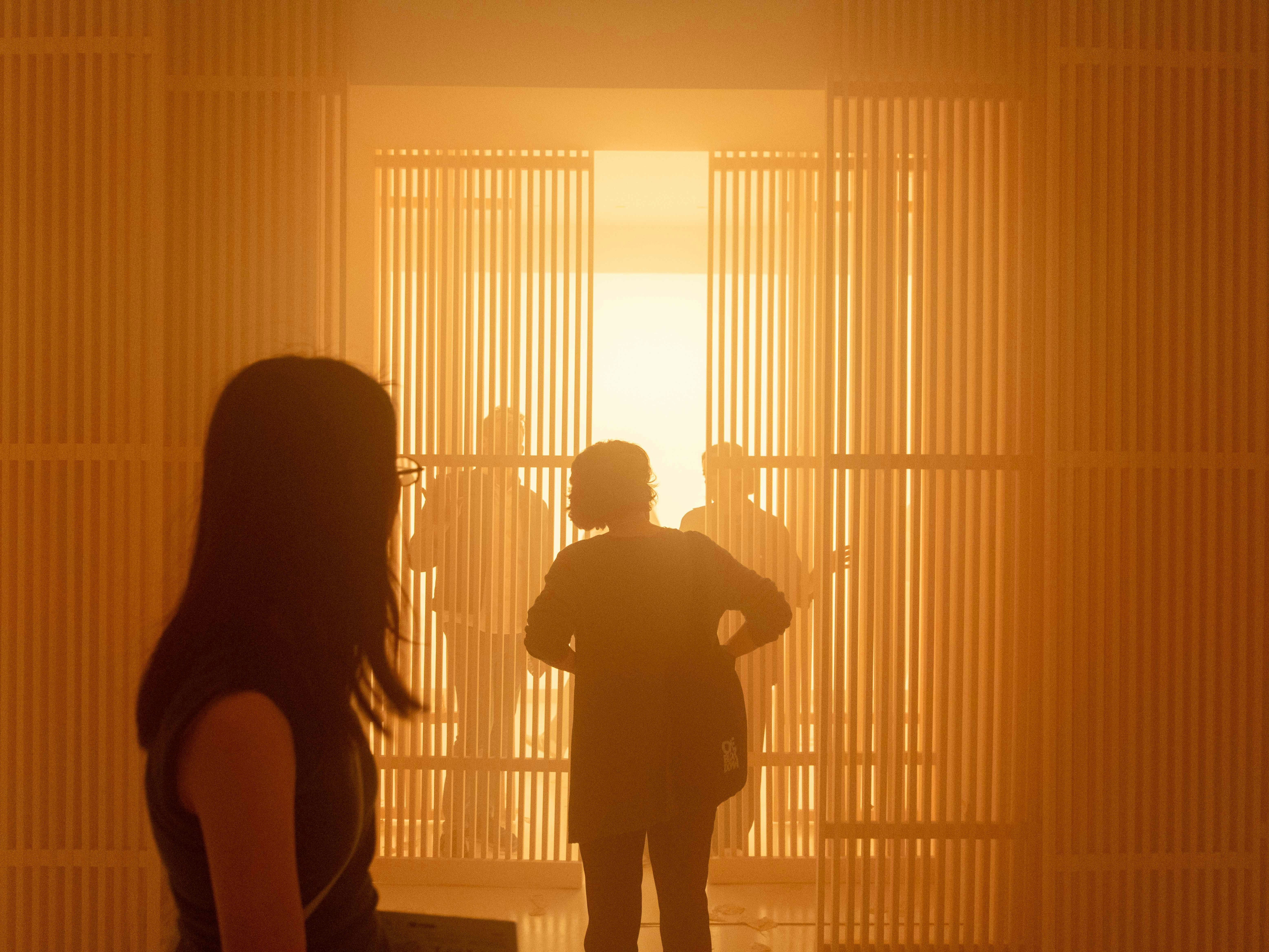 Backlit silhouettes through a golden lattice at doorway
