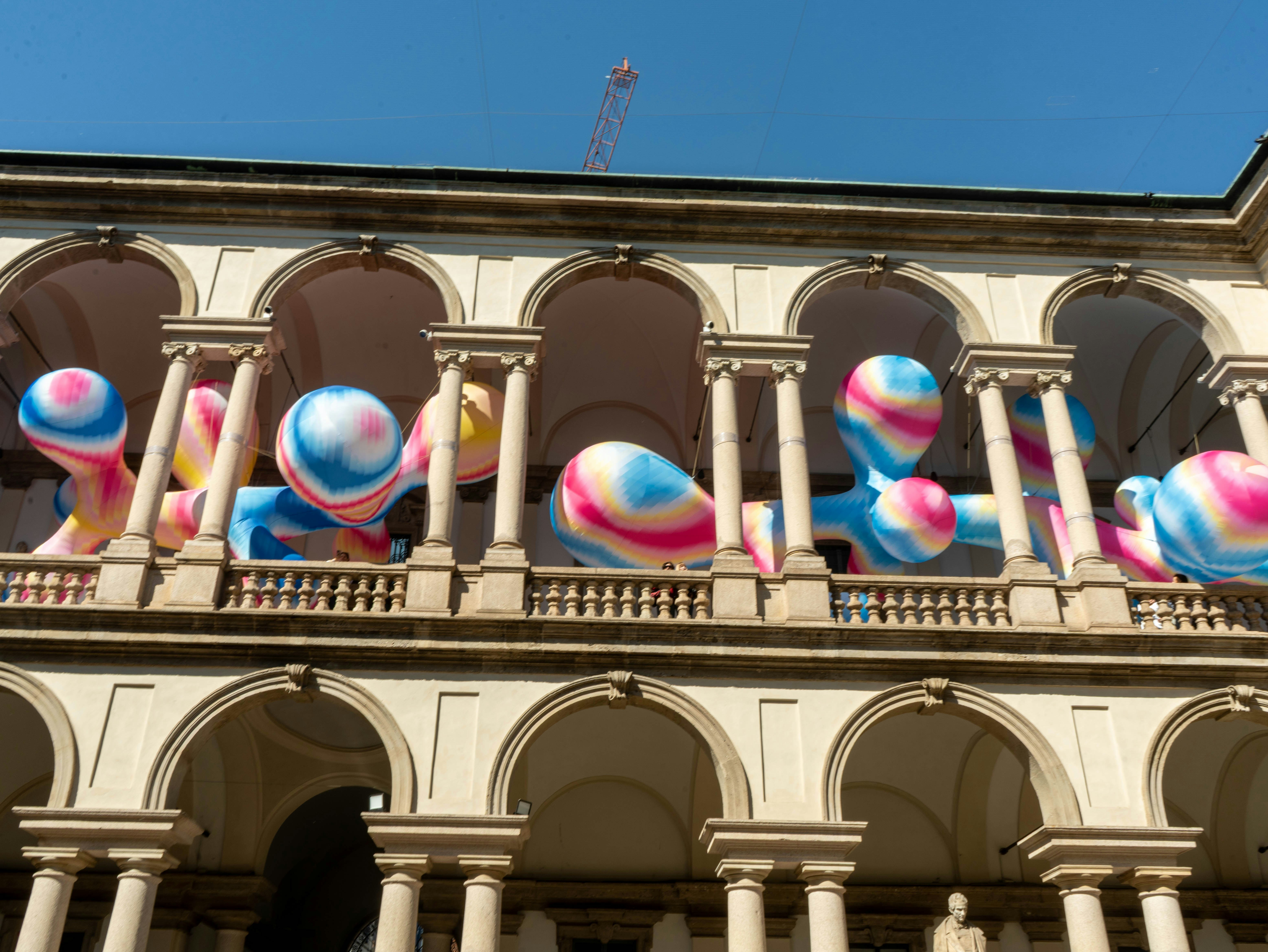Candy-Colored Ambassadors on a Classical Balcony