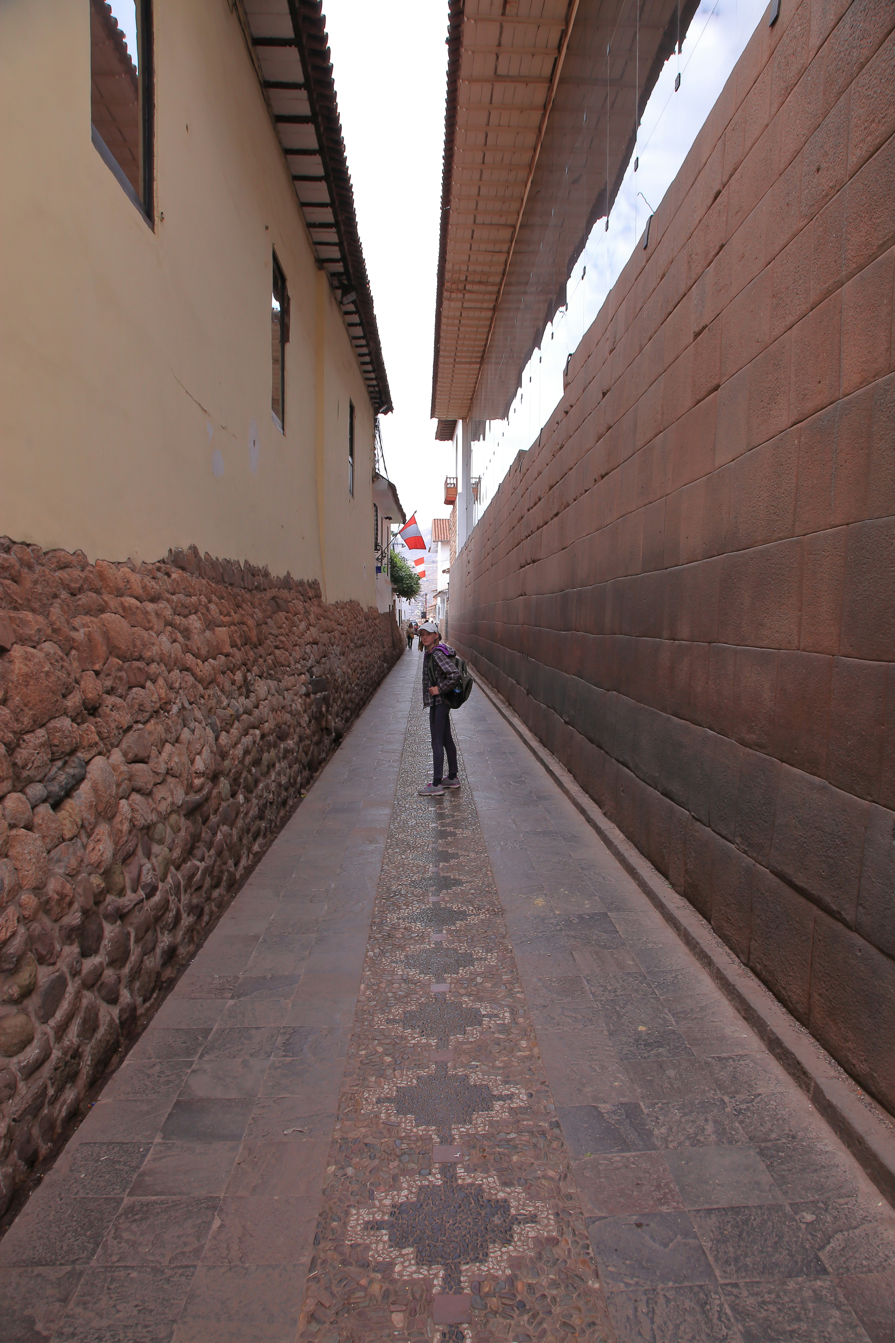 Alley Walk: A Lone Photographer Traverses a Narrow Andean-esque Passage