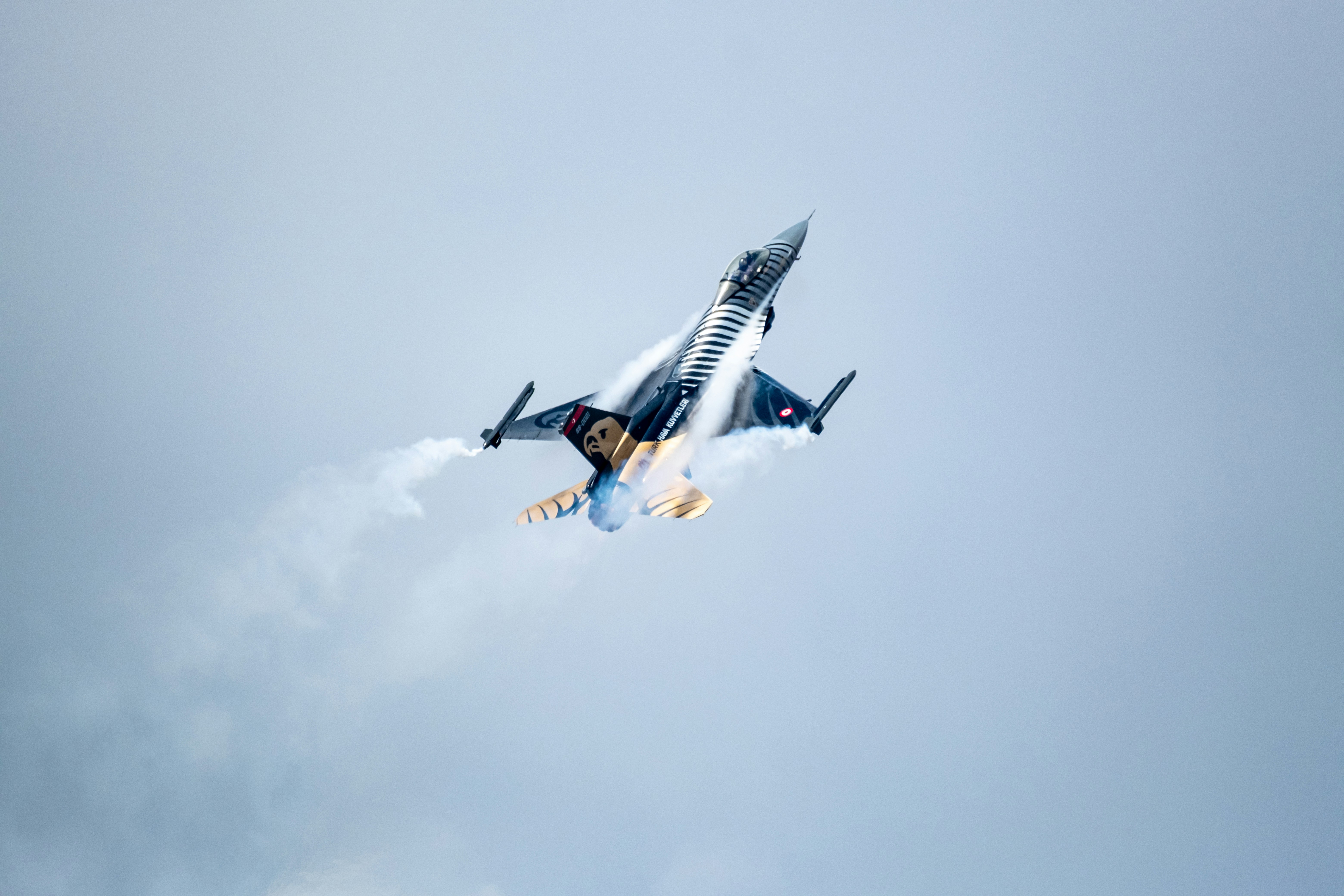 Jet in ascent: a sleek fighter slices through pale blue skies
