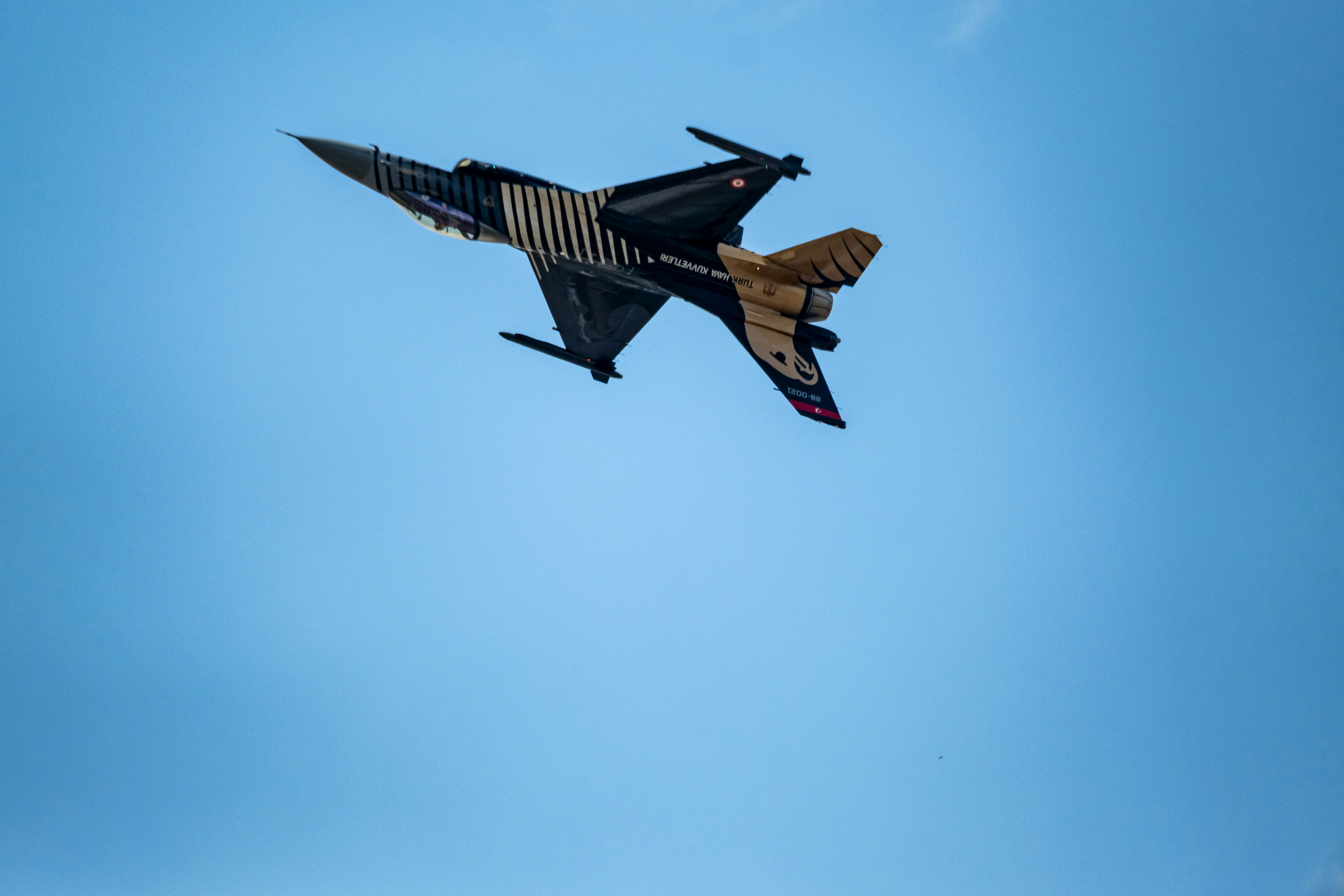 Jet-painted performer: a tactical jet skims the blue canvas