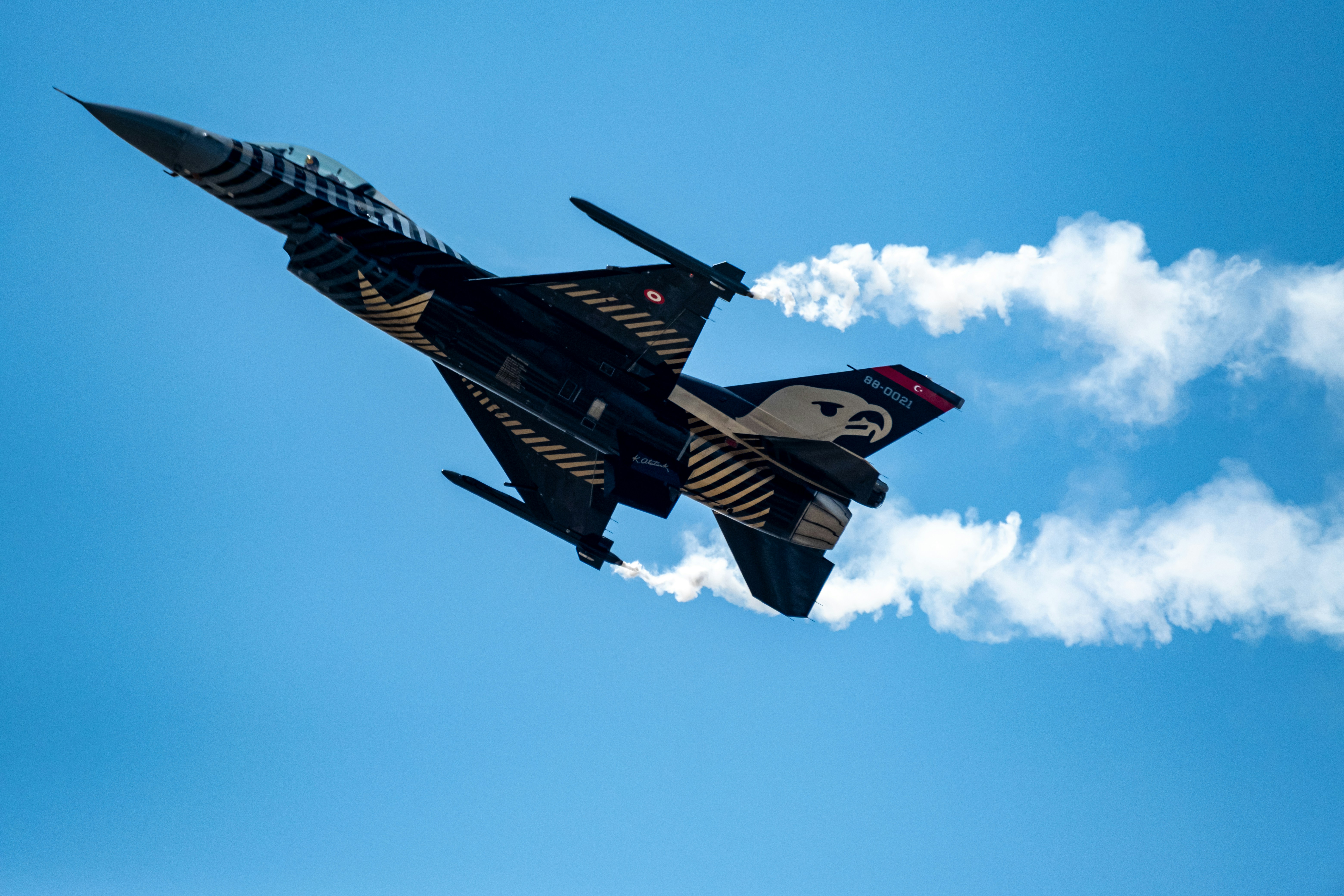 Thumbs-up from the sky: a daring flyby of a jet with contrail streaks