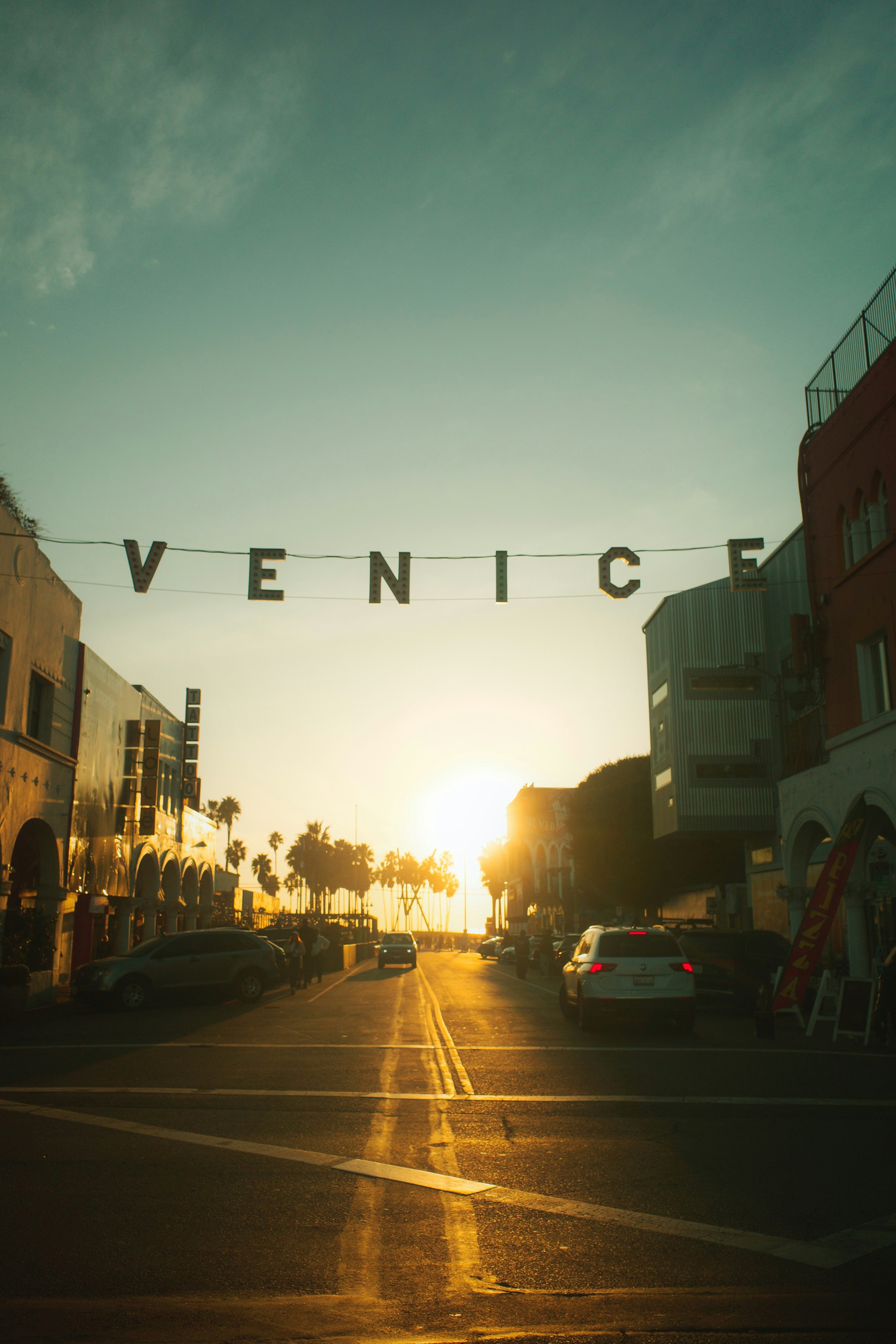 Golden Hour on Venice Boulevard: Street Sign, Sunburst Over Palm-Shaded Cars