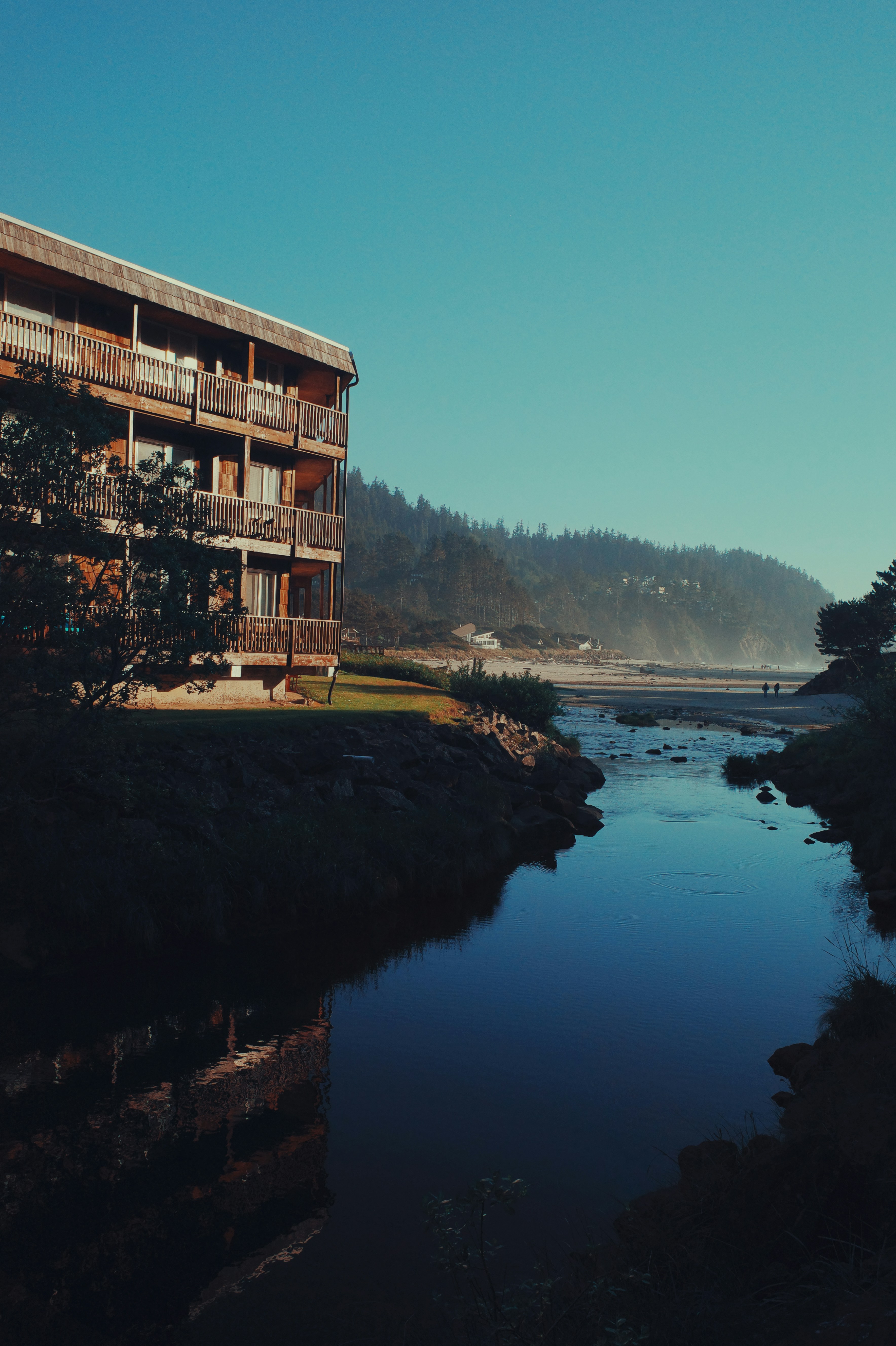 Coastal Retreat: Sunlit Hotel Facade Overlooking a Quiet River
