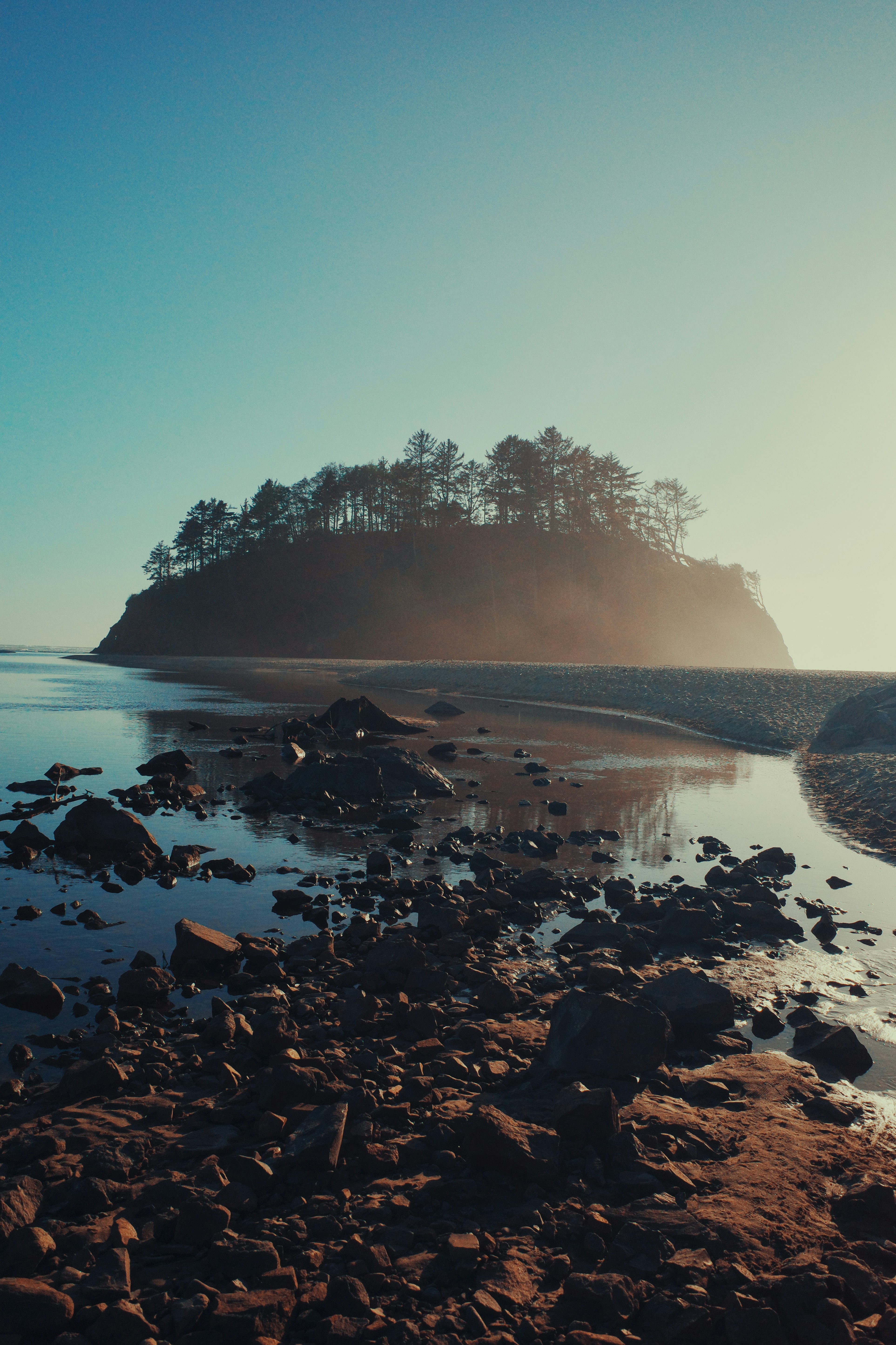 Sunlit Island Ridge Amid Tidal Reflections