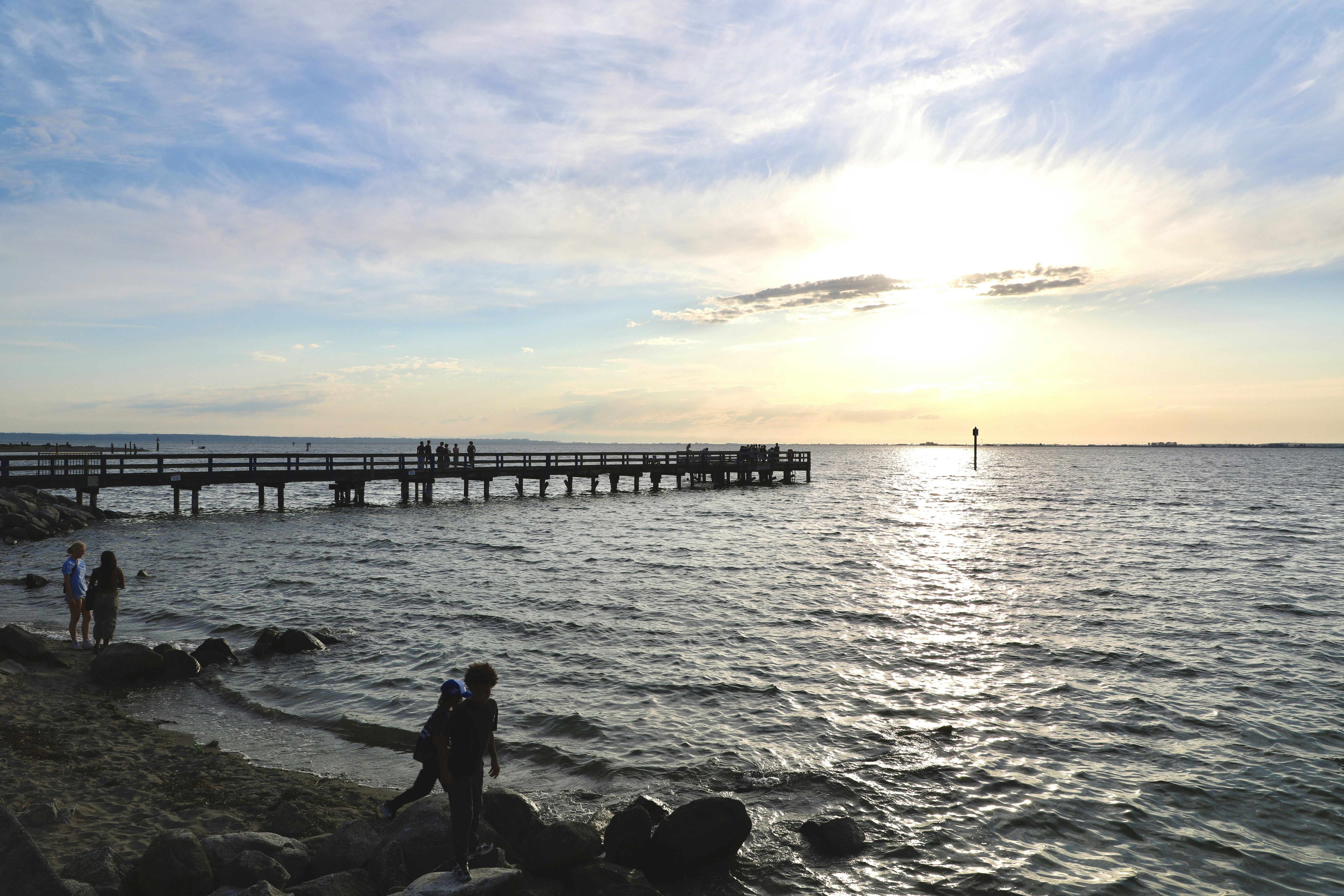 Golden Hour at the Pier: Sunset Light over a Seaside Scene