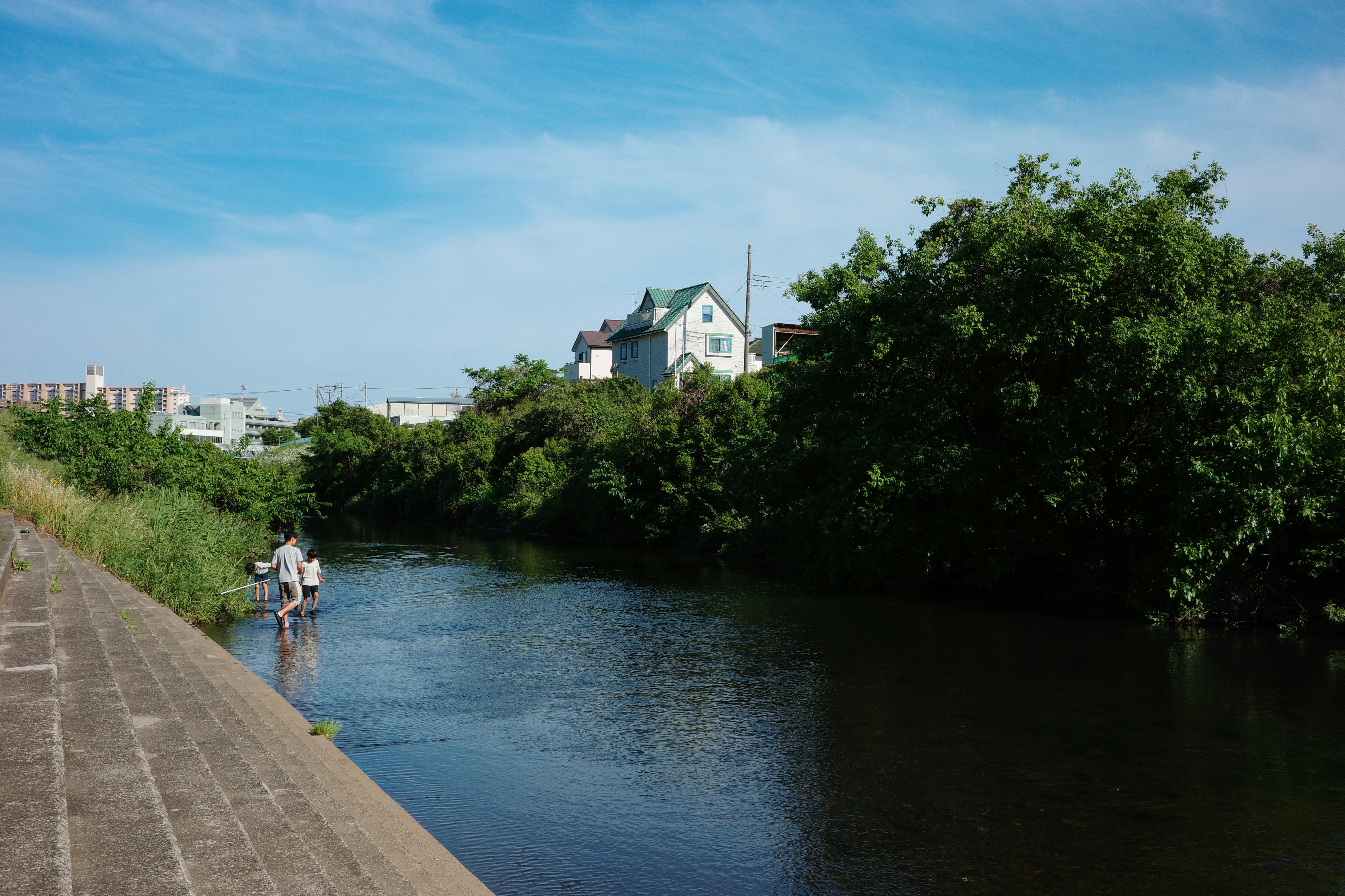Riverside Walkers: Quiet Currents by a Suburban Channel