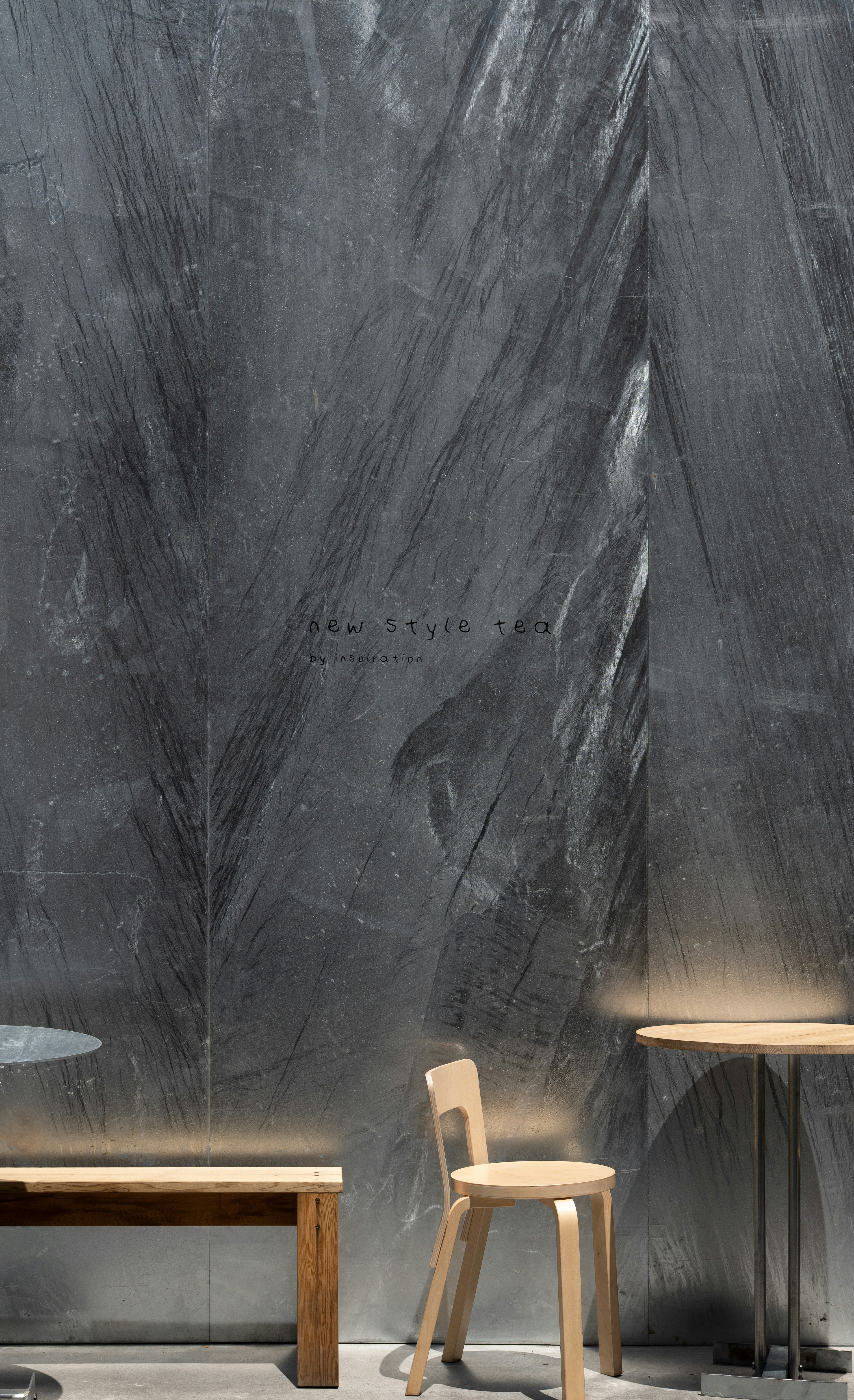 Minimalist Café Scene with Marble Wall and Light Wood Furniture