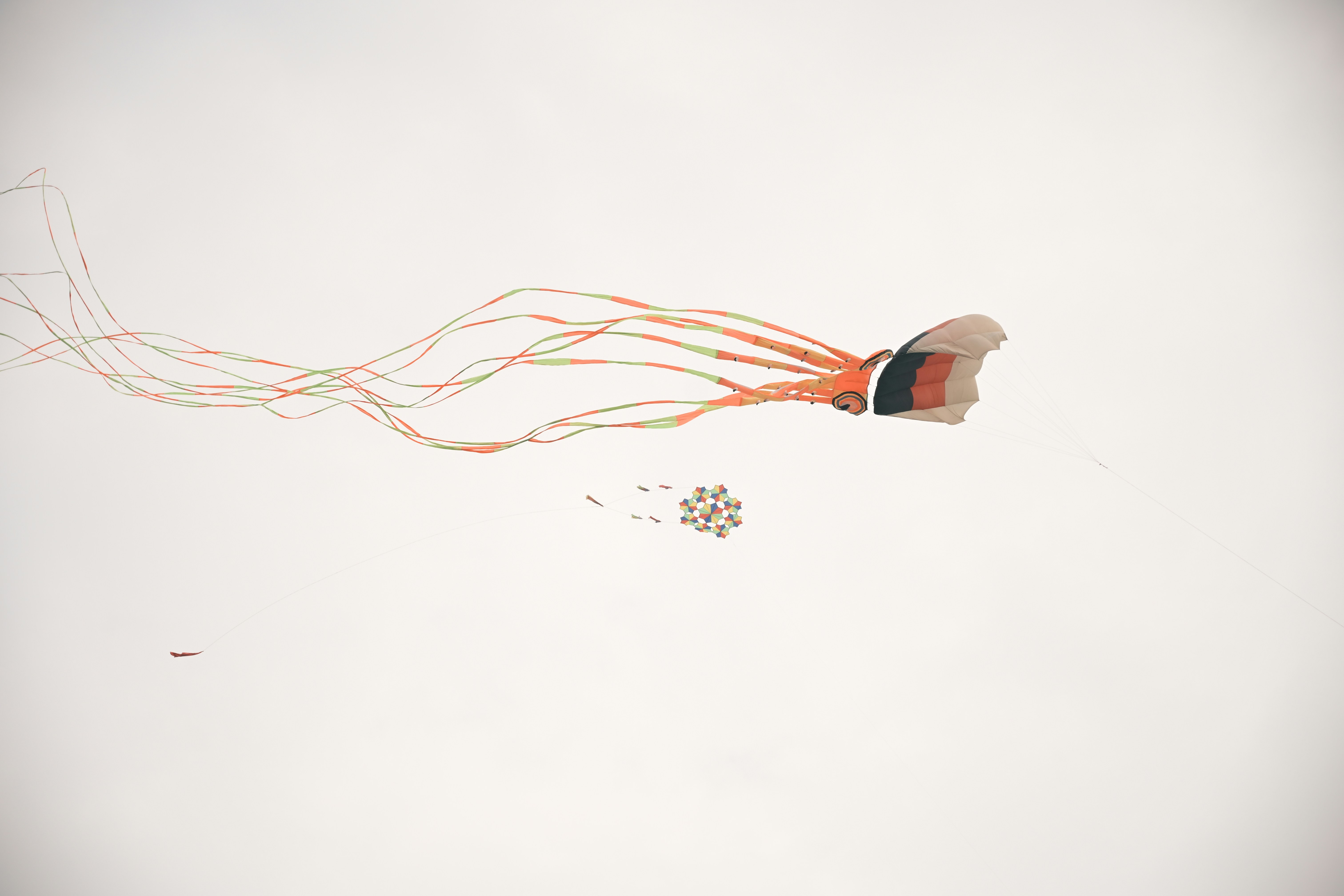 High-Altitude Rescue: A Parachute Trails Over a Pale Sky