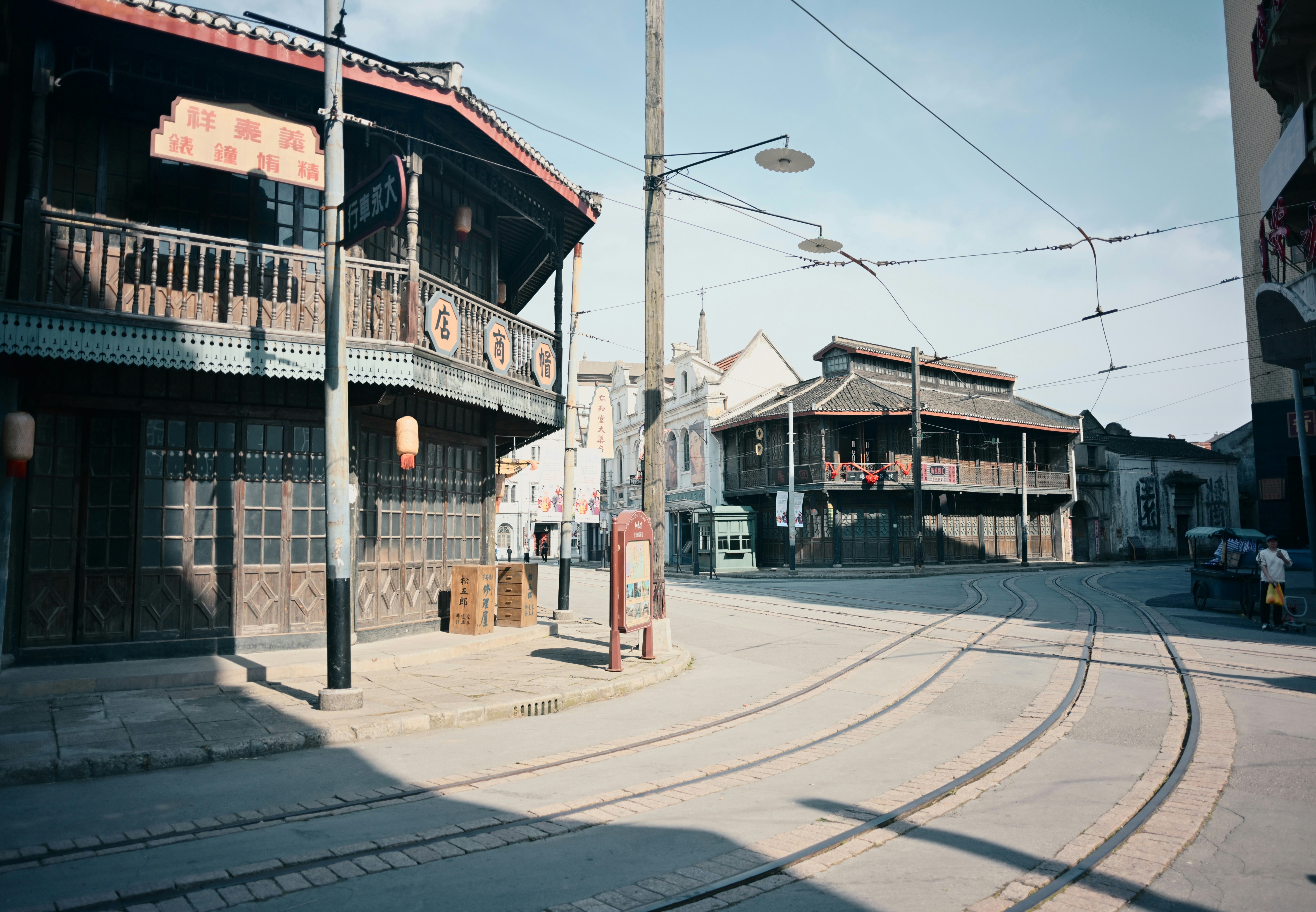 Sunlit streetcar rails vanish into a quiet historical alley
