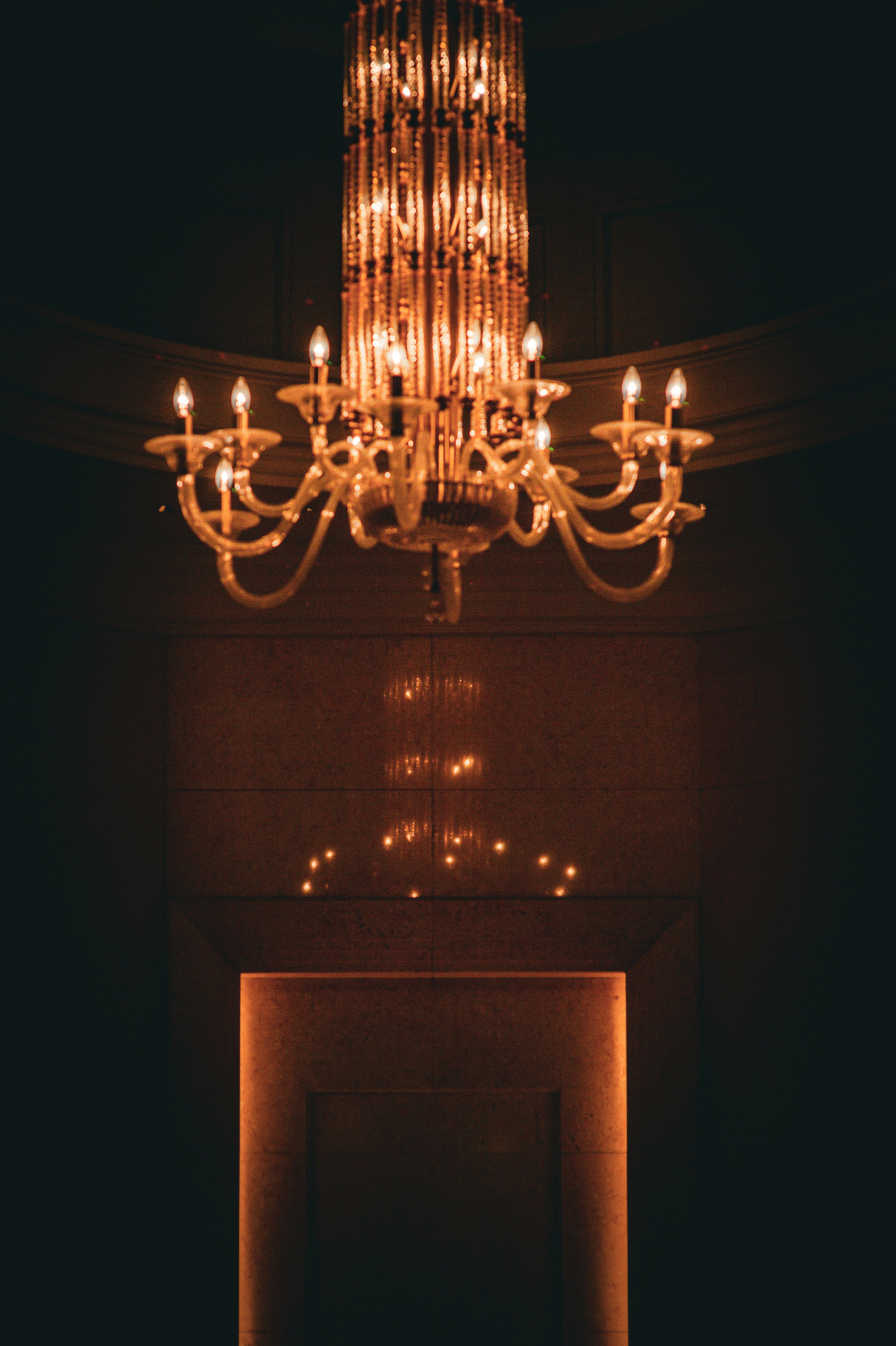 Amber Glow: Chandeliers and Shadowed Hallway