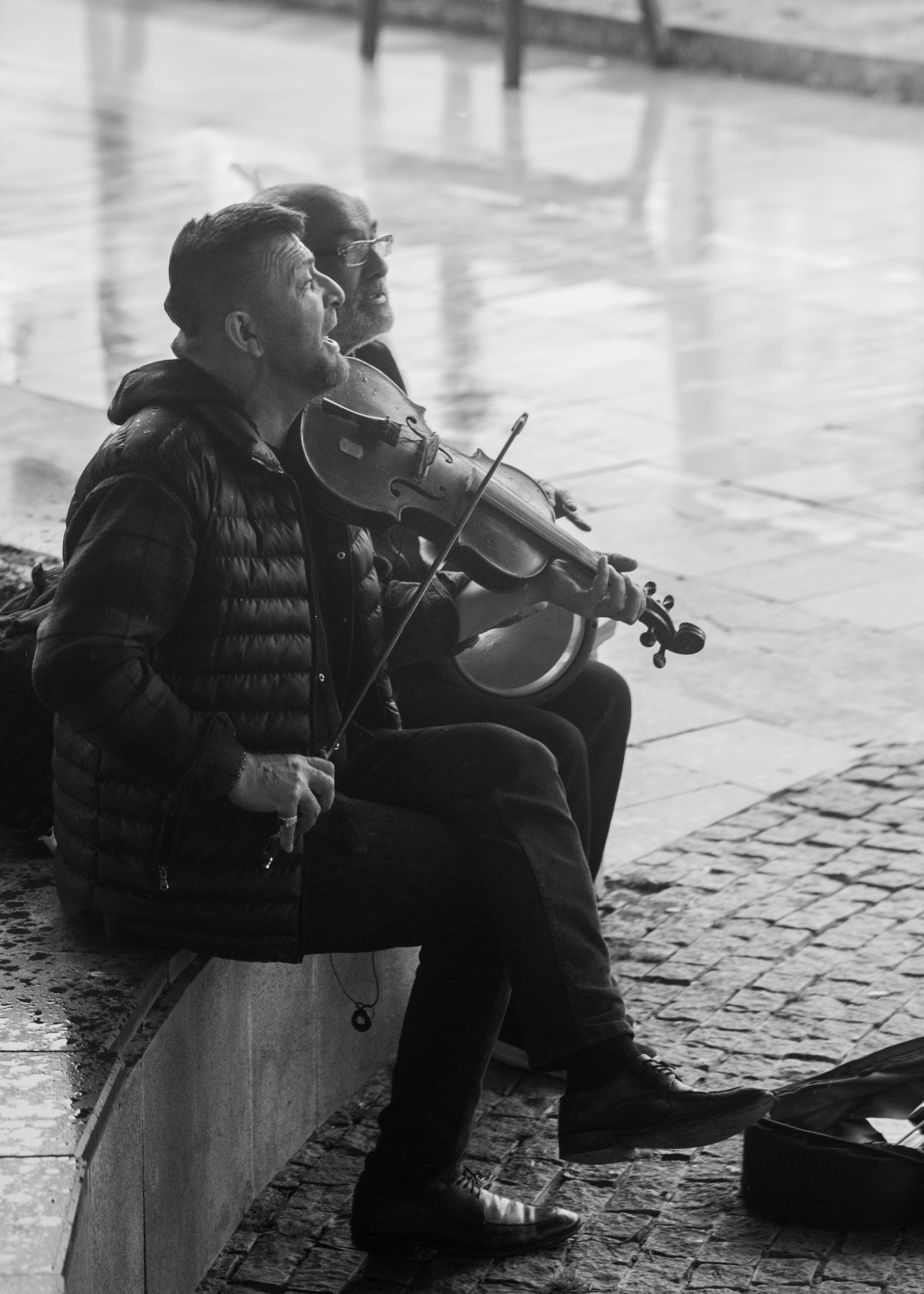 Two Street Musicians in Rain on a City Steps