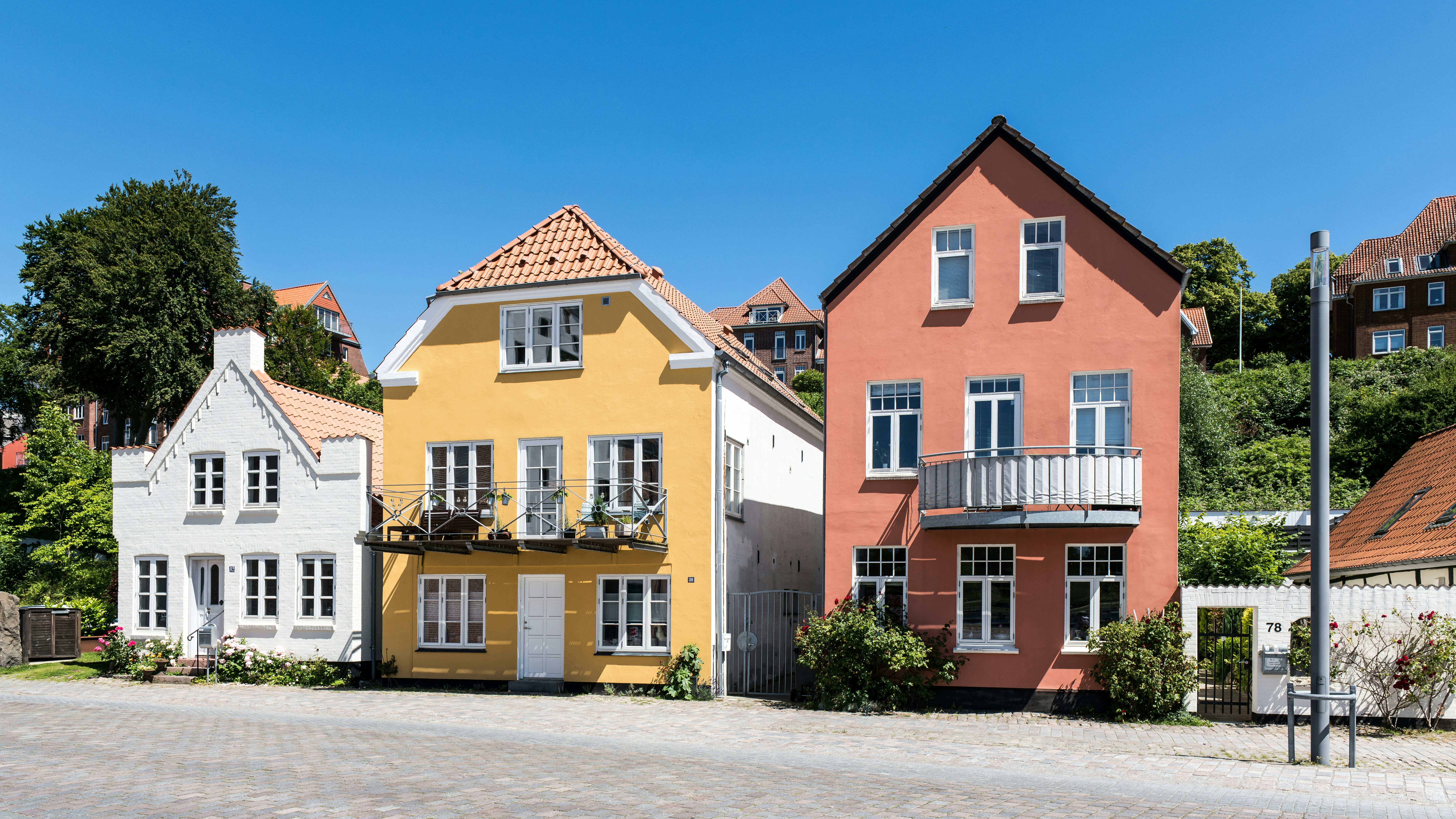 Sunlit Row: Colorful Dutch-Style Townhouses under a Clear Blue Sky