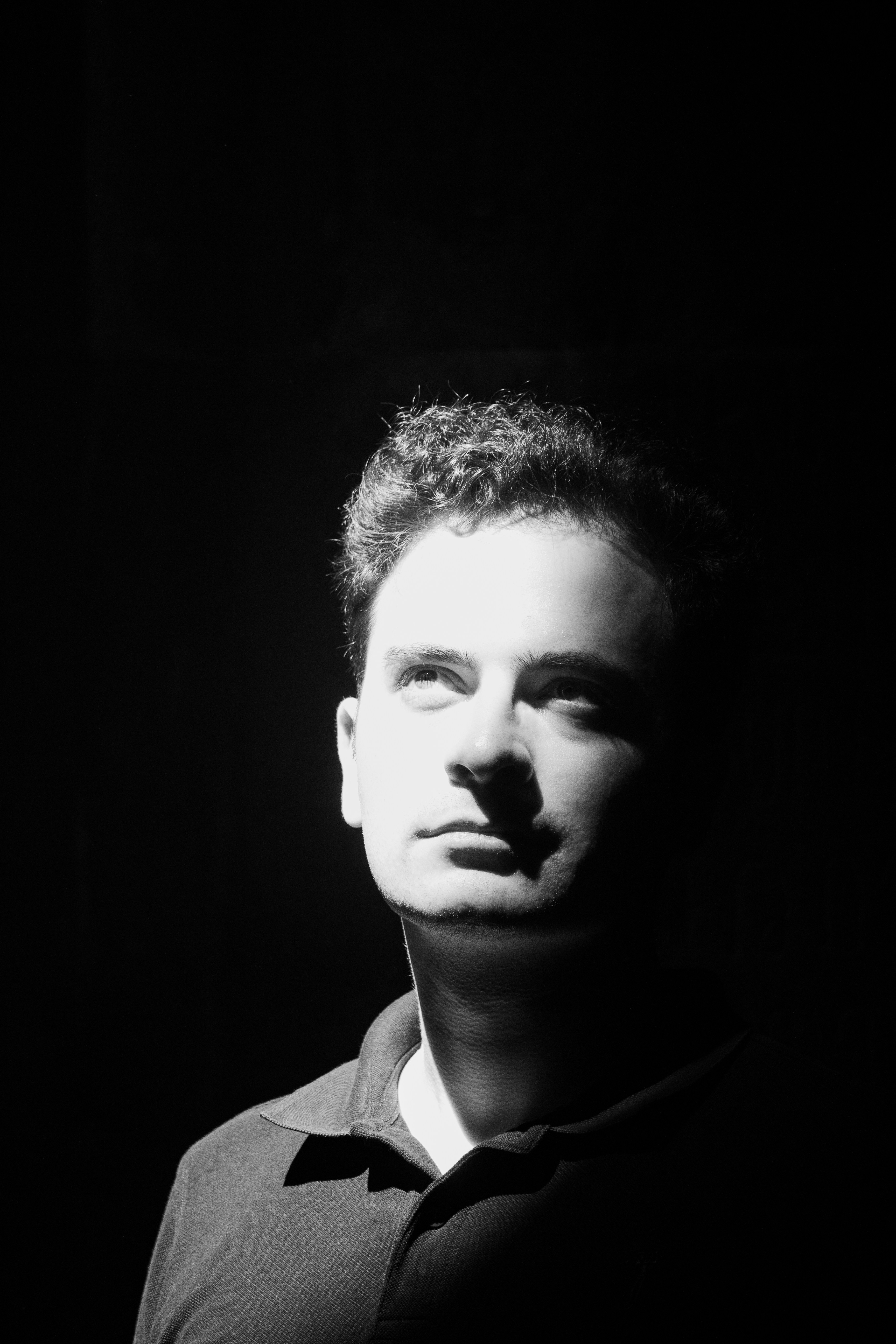 Spotlit Contemplation: A Portrait in High-Contrast Light