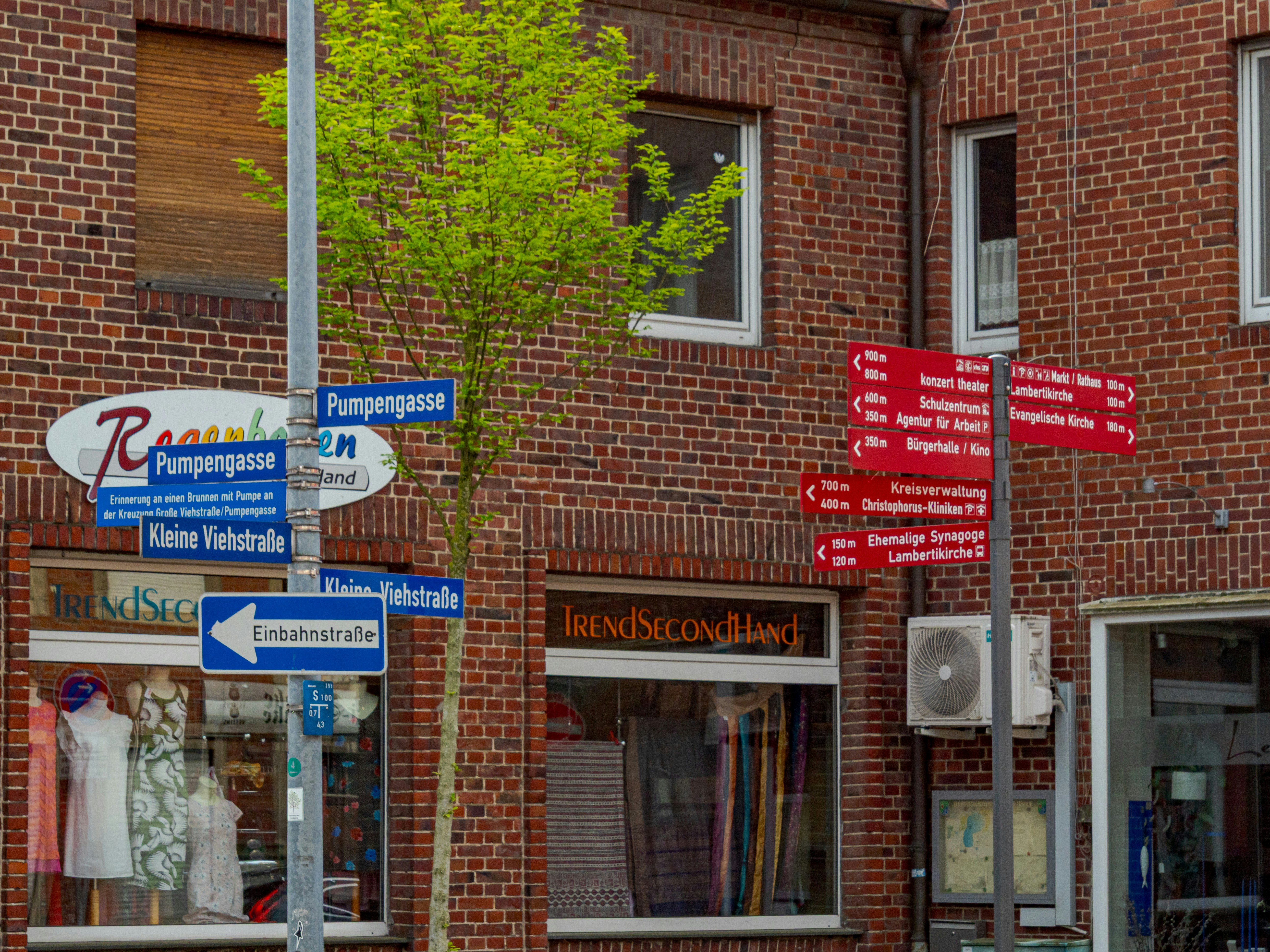 Shopfronts and Signpost Mosaic on a Brick Street