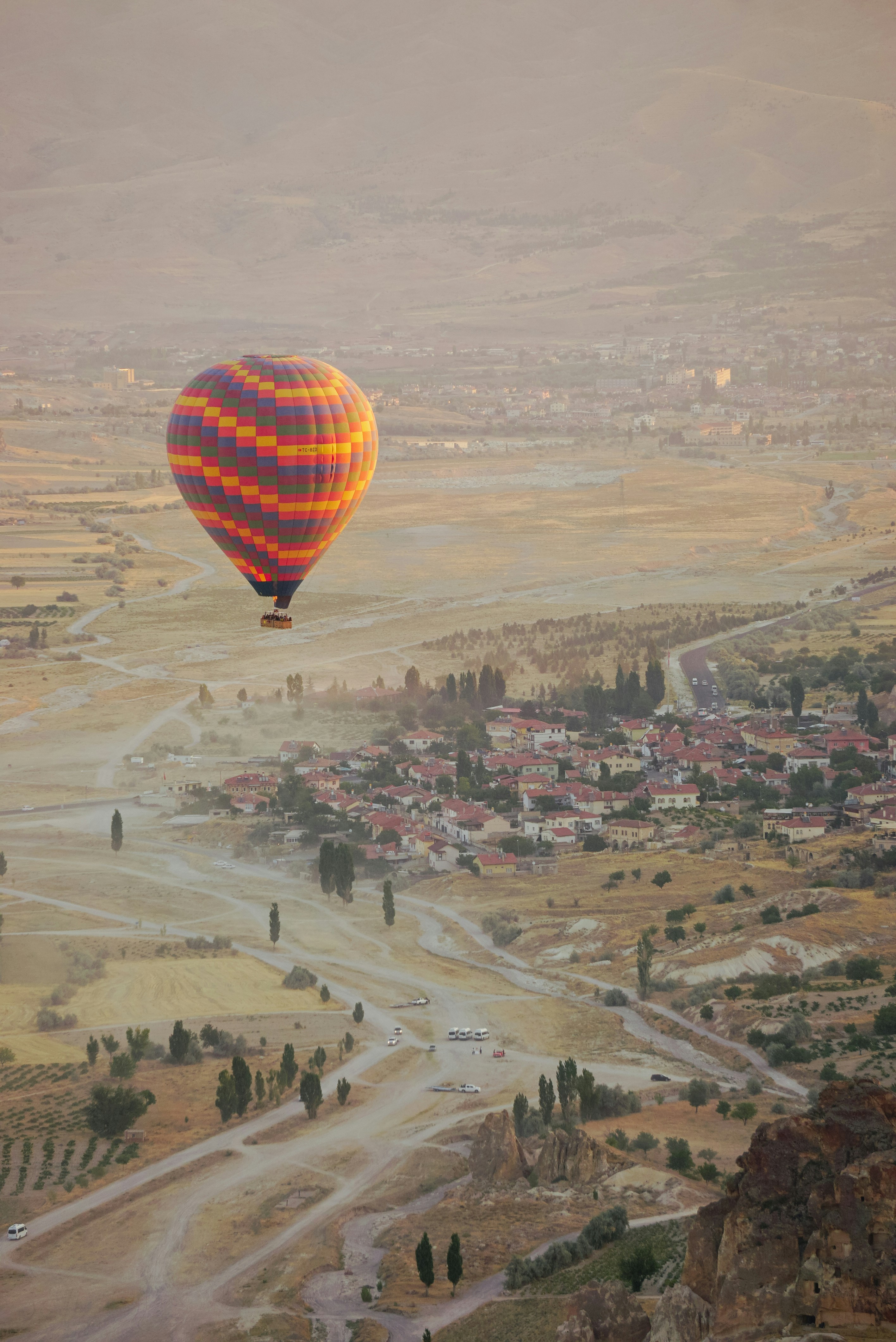 Strata of Air: A Vibrant Balloon Over a Quiet Valley