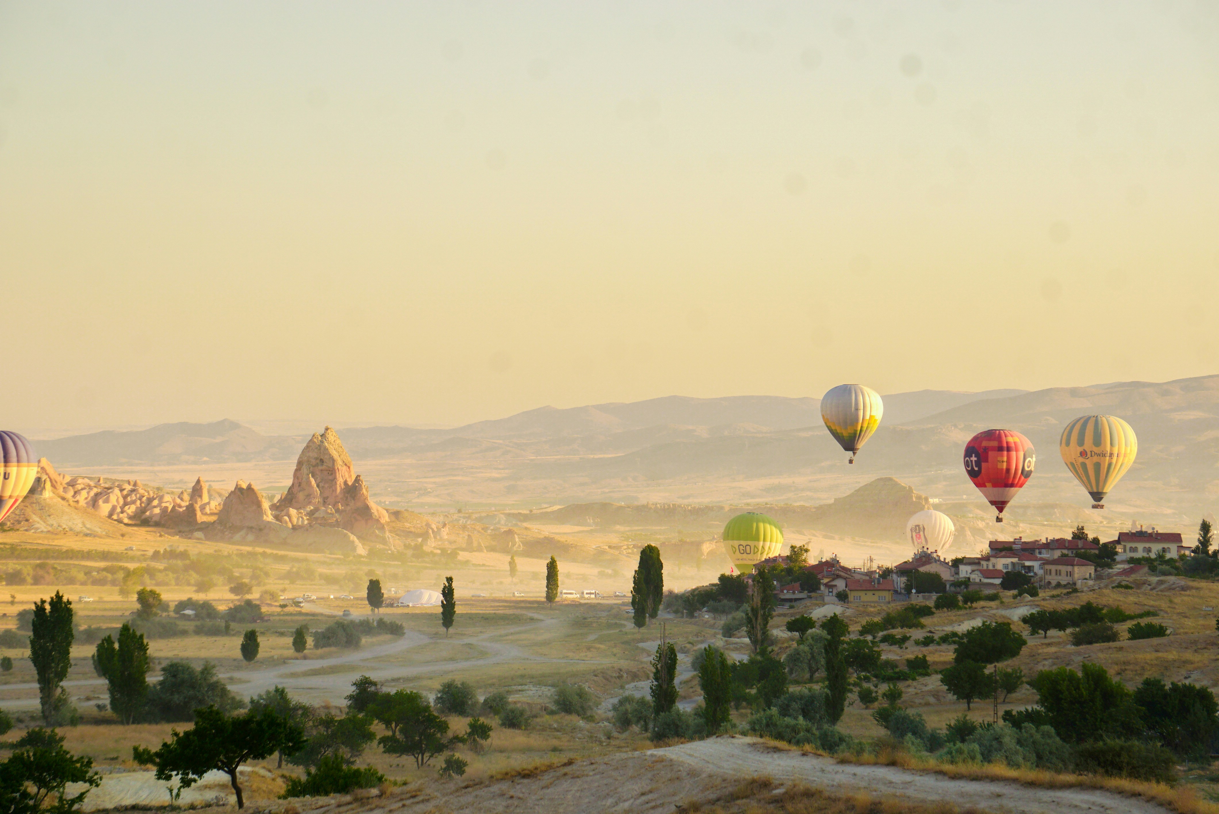 Elevated Dawn: Hot Air Balloons Above Arid Valleys