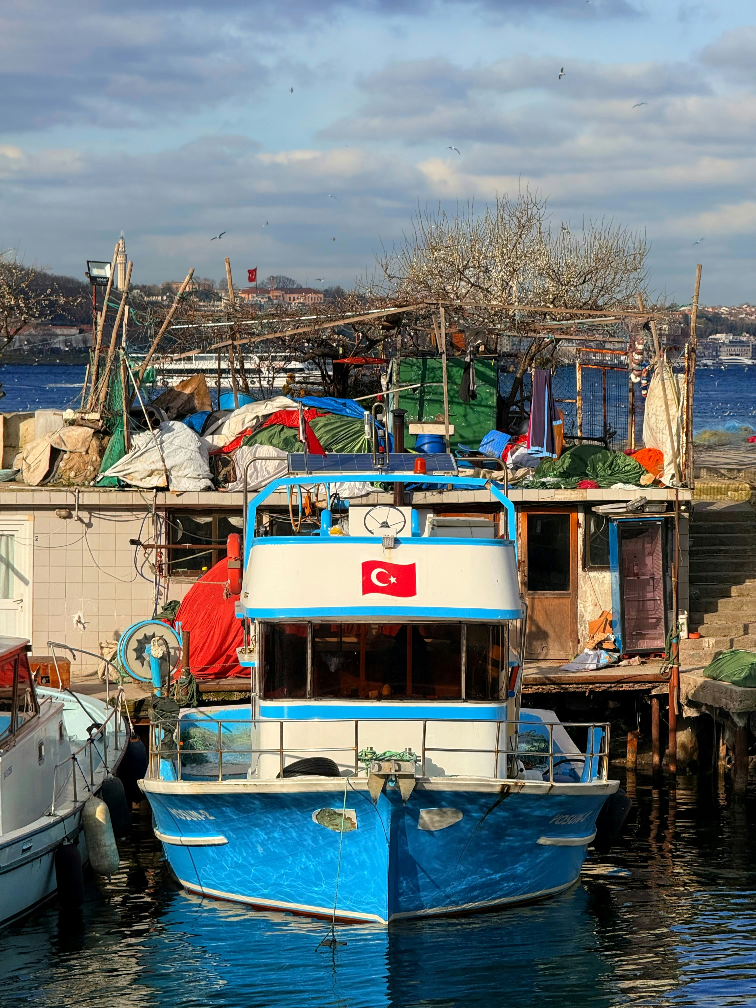 Blue Boat at Dappled Harbor: A Quay of Tents and Turquoise Reflections