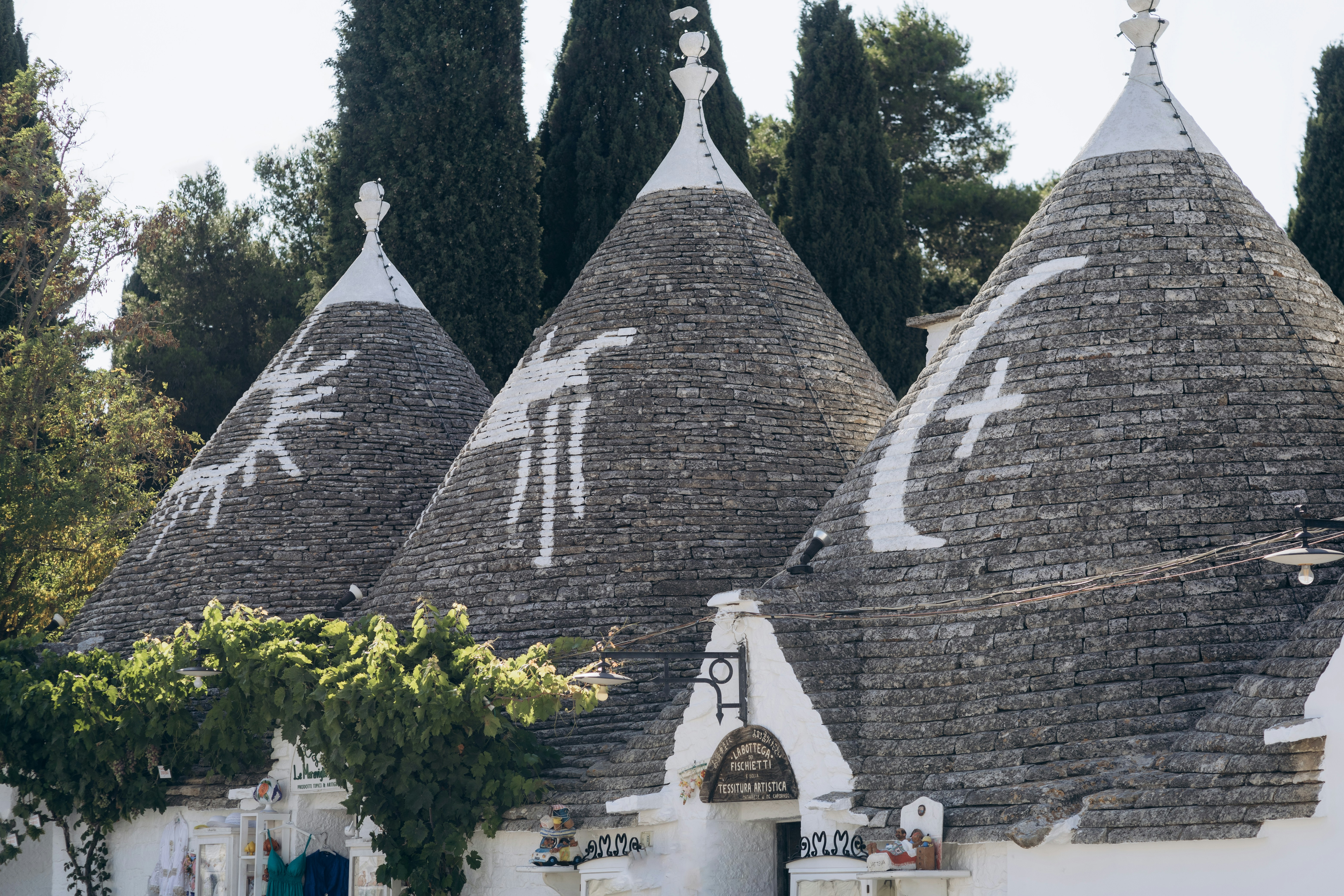 Cone-Shaped Trulli with Painted Symbols in Blooming Orchard