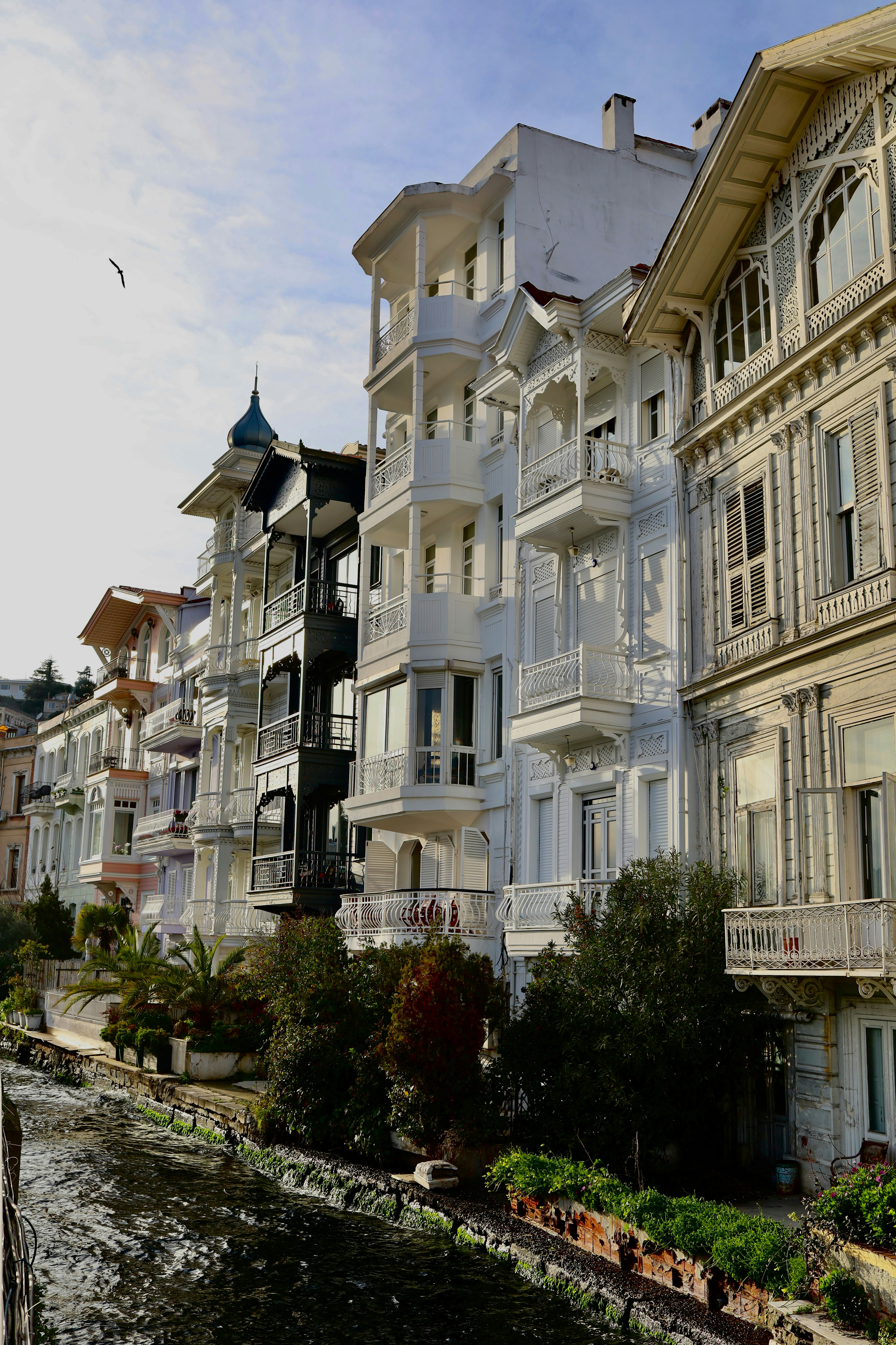 Whitewashed balconies along a sunlit canal