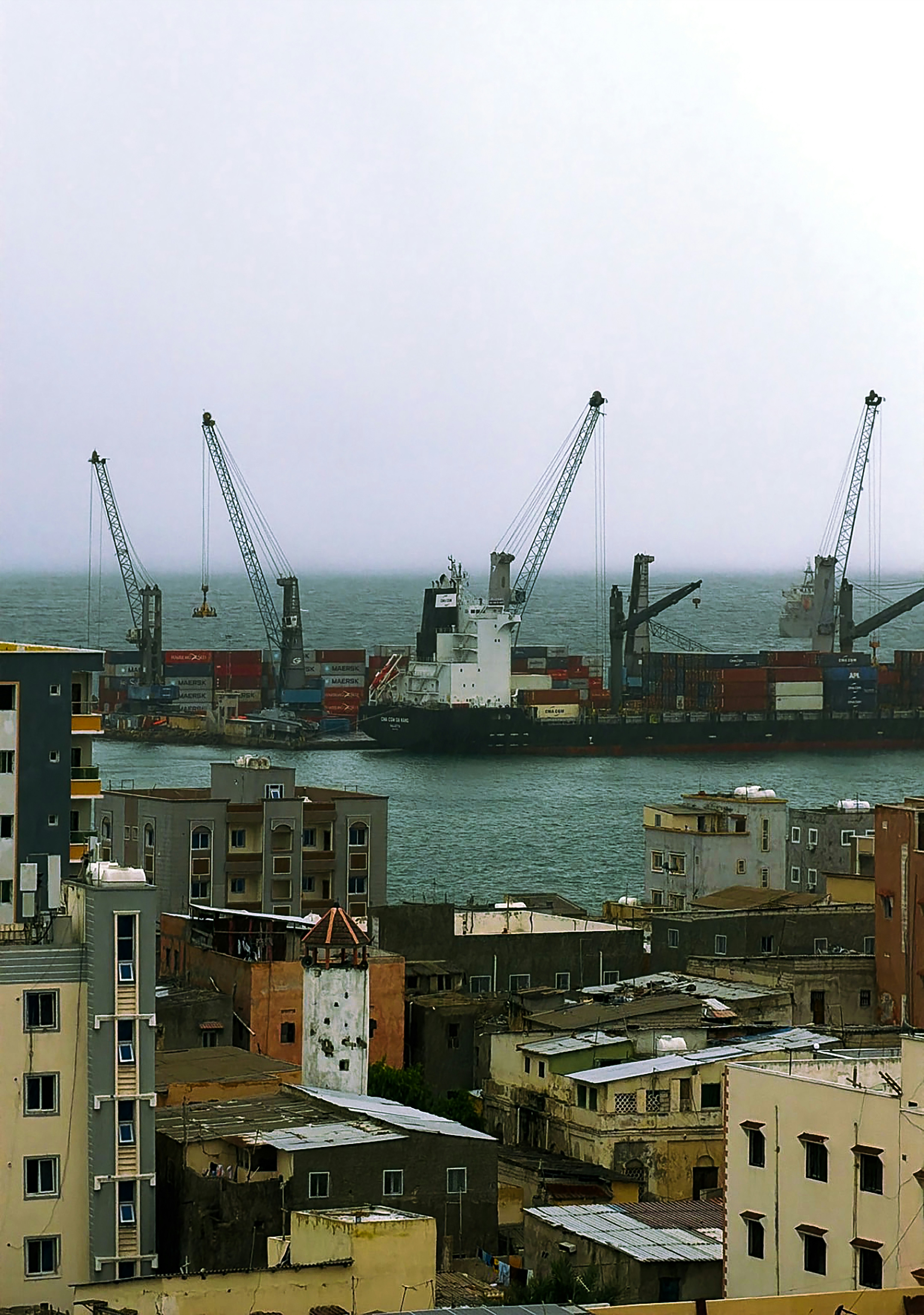 Harbor Giants: Cranes Over a Distant Sea