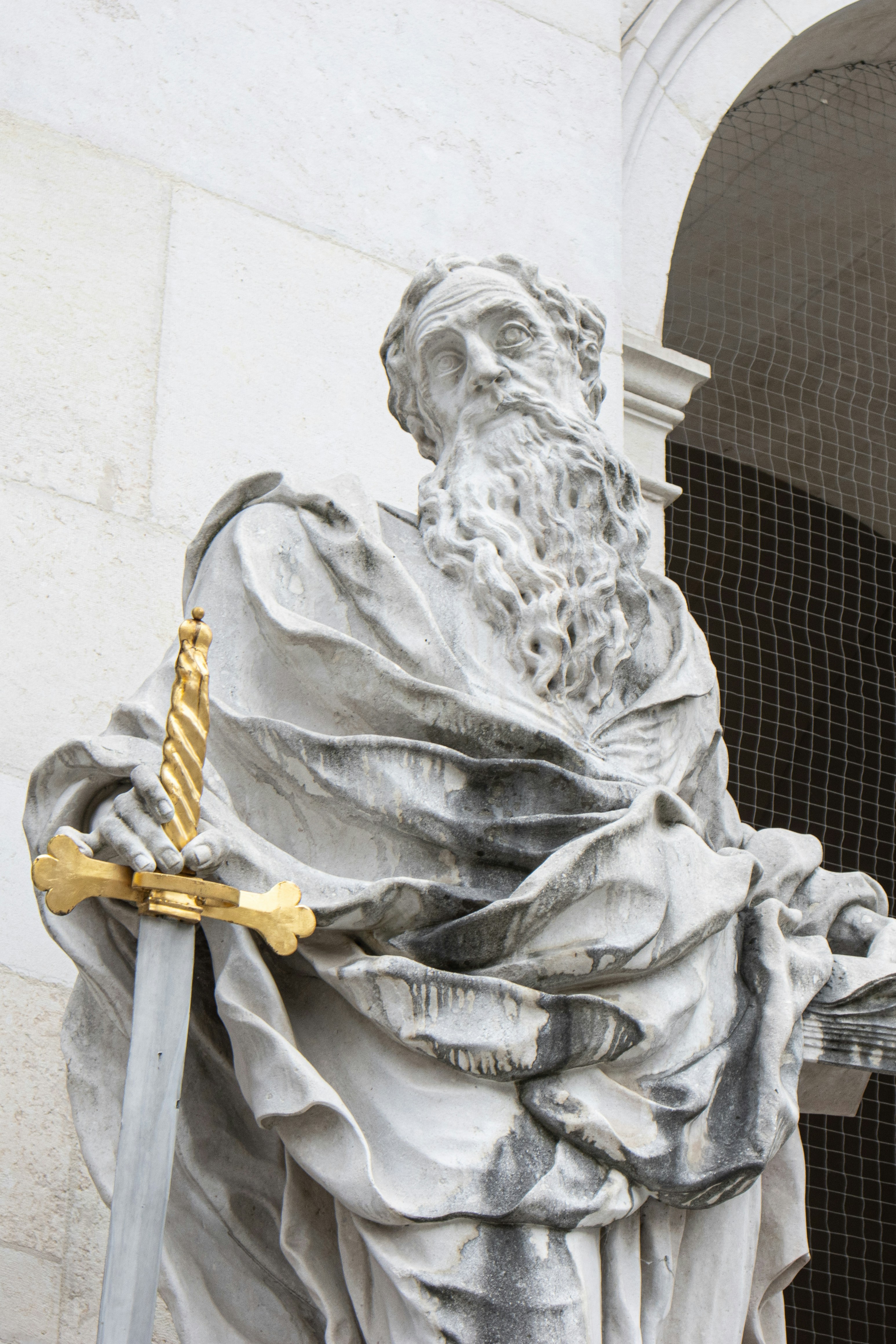 Stone Sage with Goldened Sword in the Archway