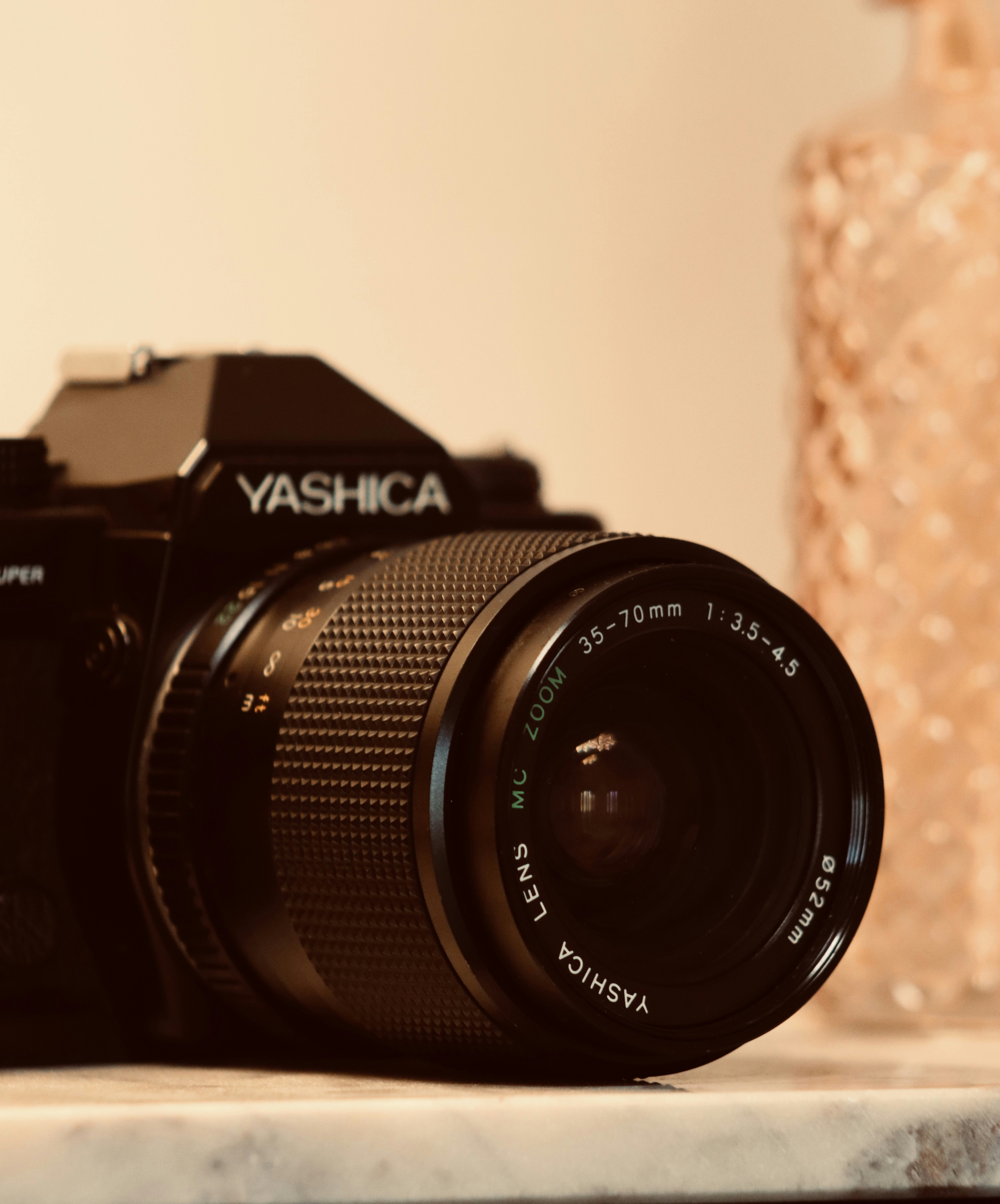 Portrait of a Classic Lens: Yashica sits in focus on a warm-lit surface
