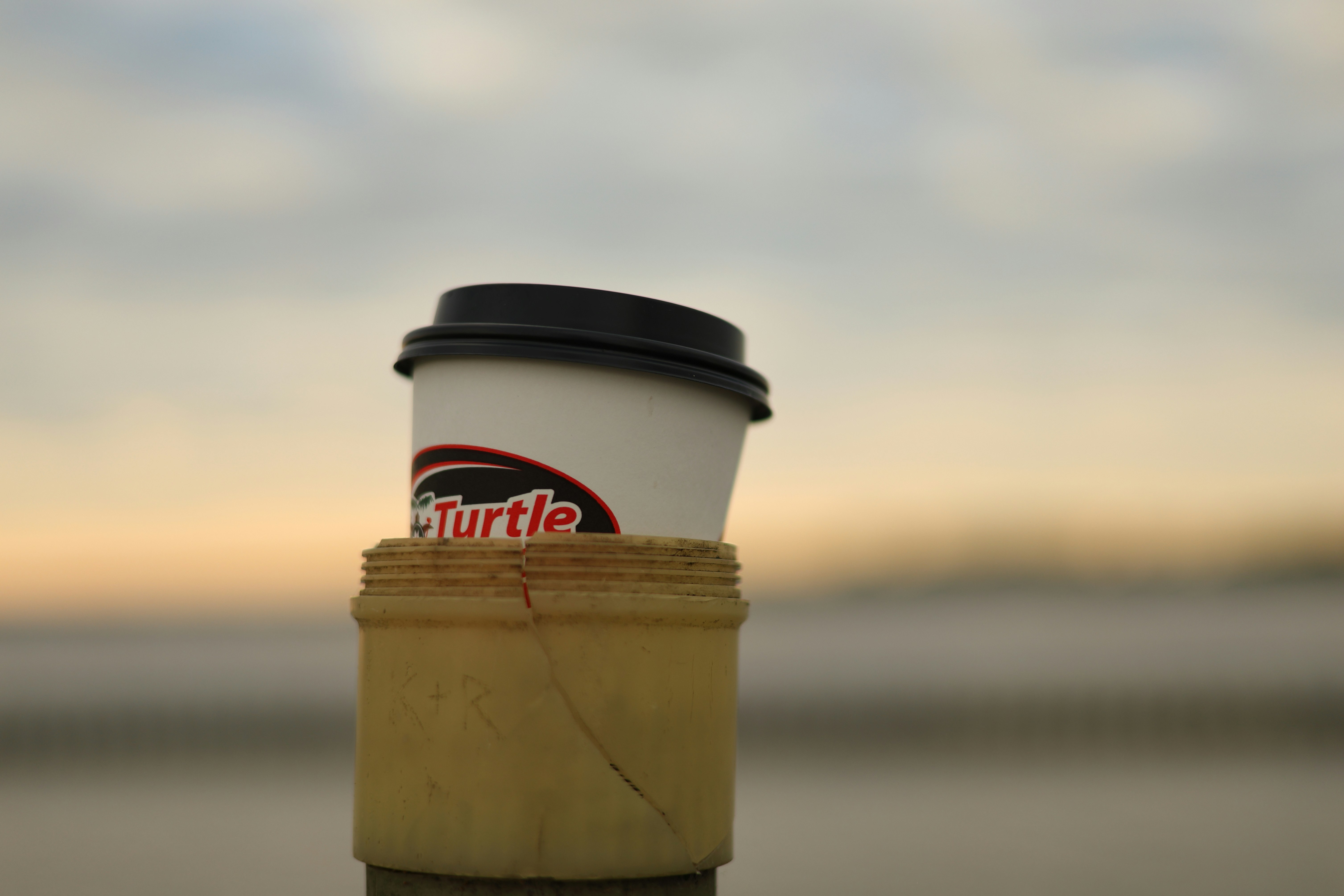 Tilted Sunrise Cup: A Solo Coffee on a Pier