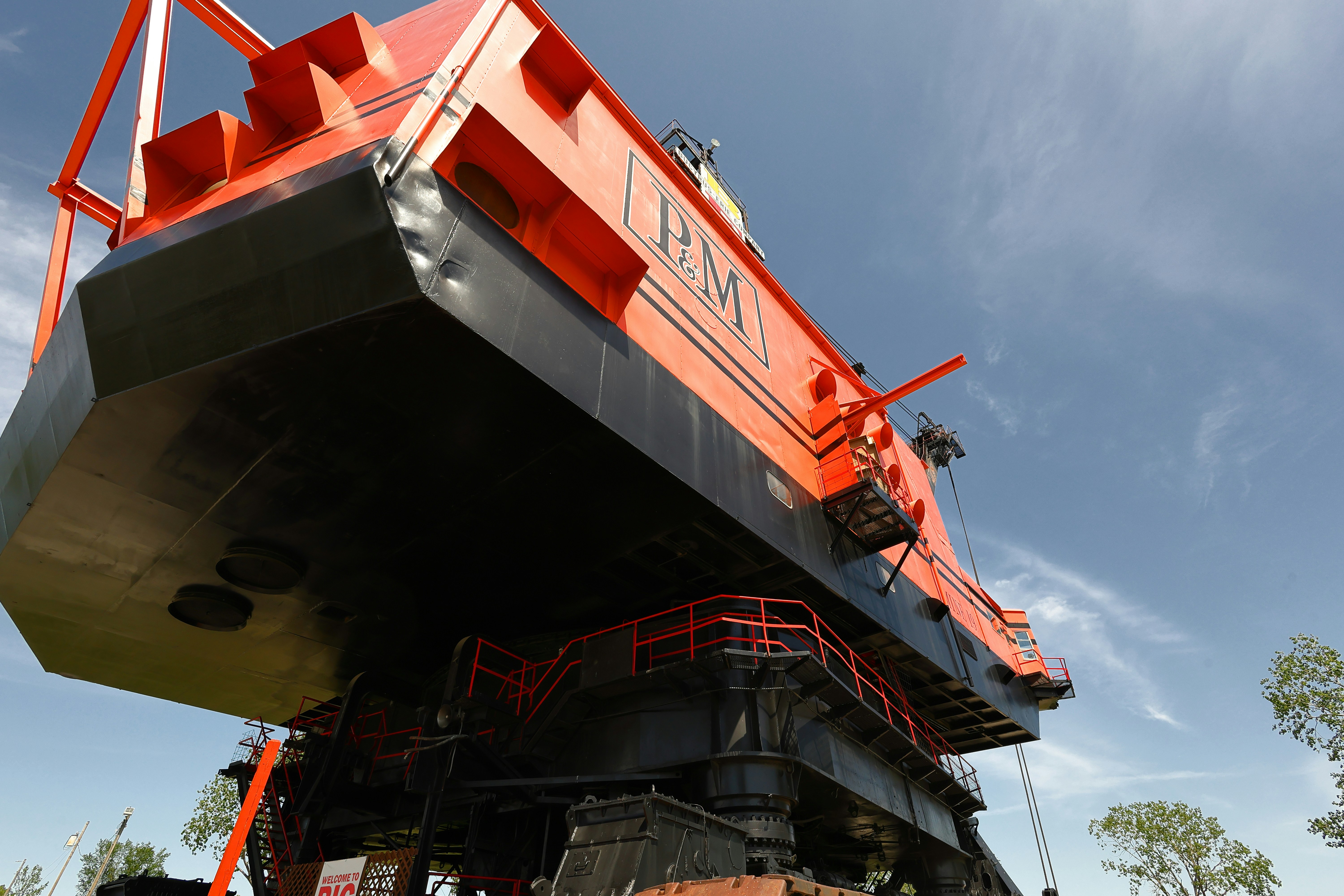 Heavy Lift: The Red Crane Vessel Rises Against a Clear Sky