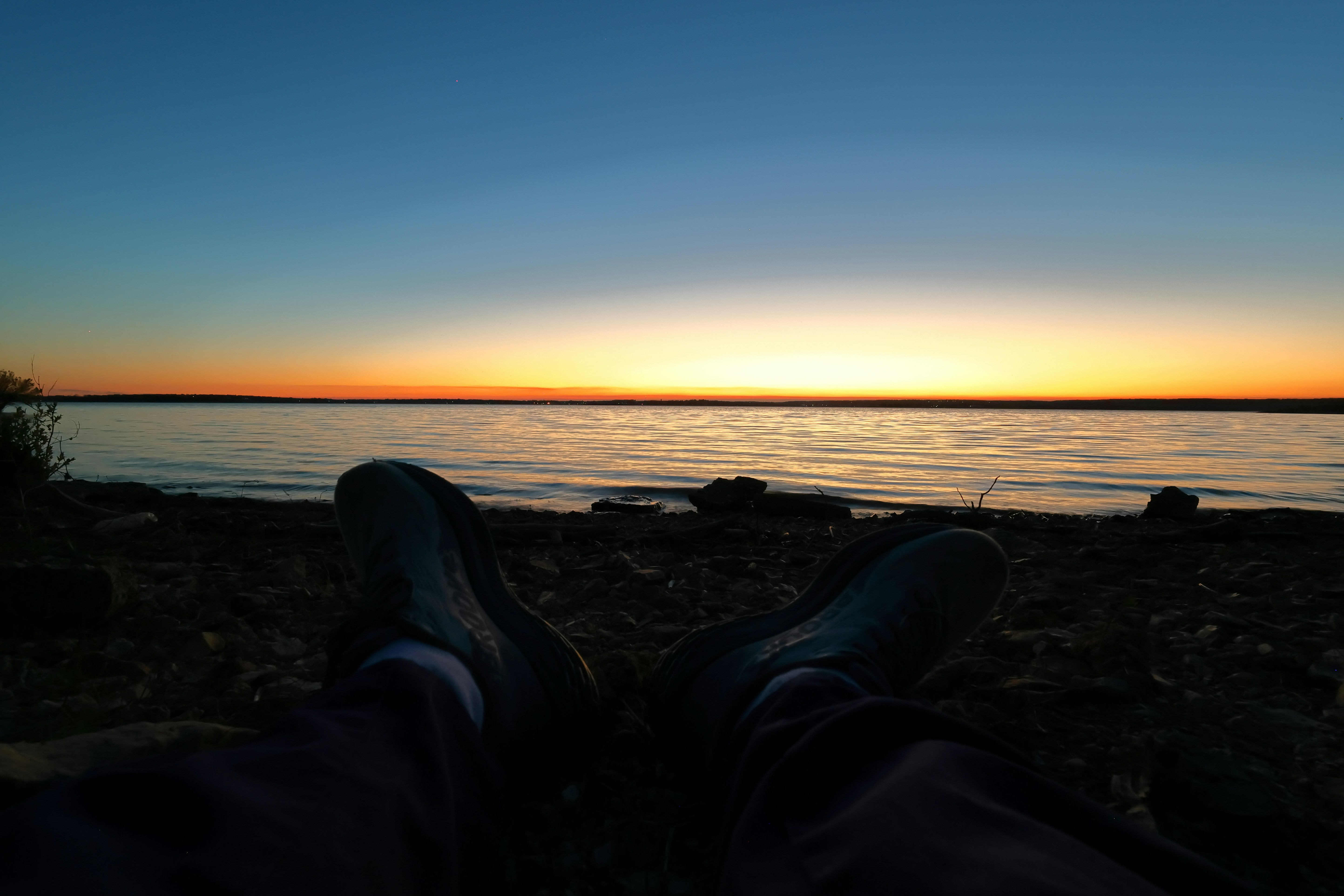 Quiet Horizon: Feet in the Sand, Sunset over a Calm Lake